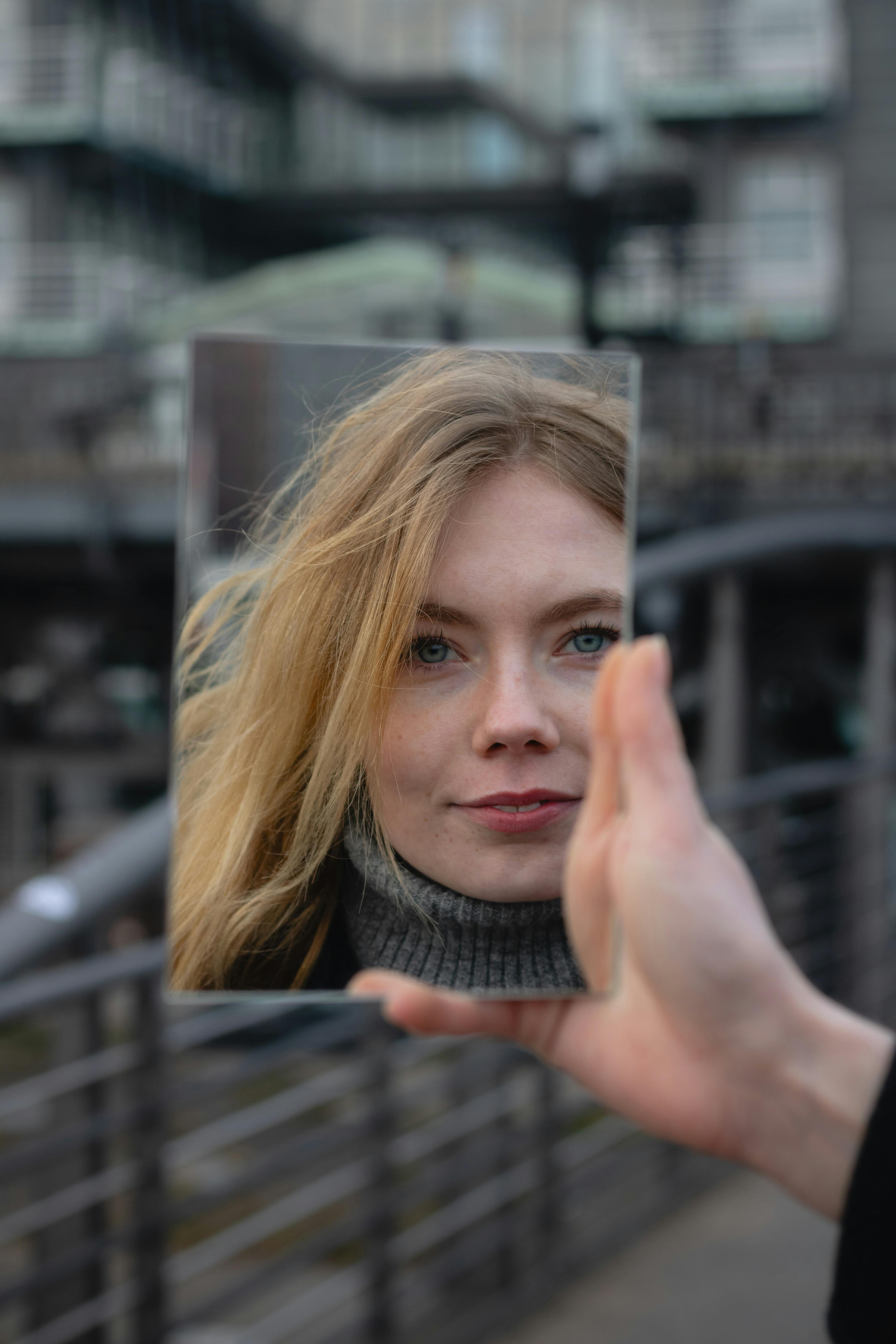 Blonde Woman Hand Holding Mirror with Face Reflection · Free Stock Photo