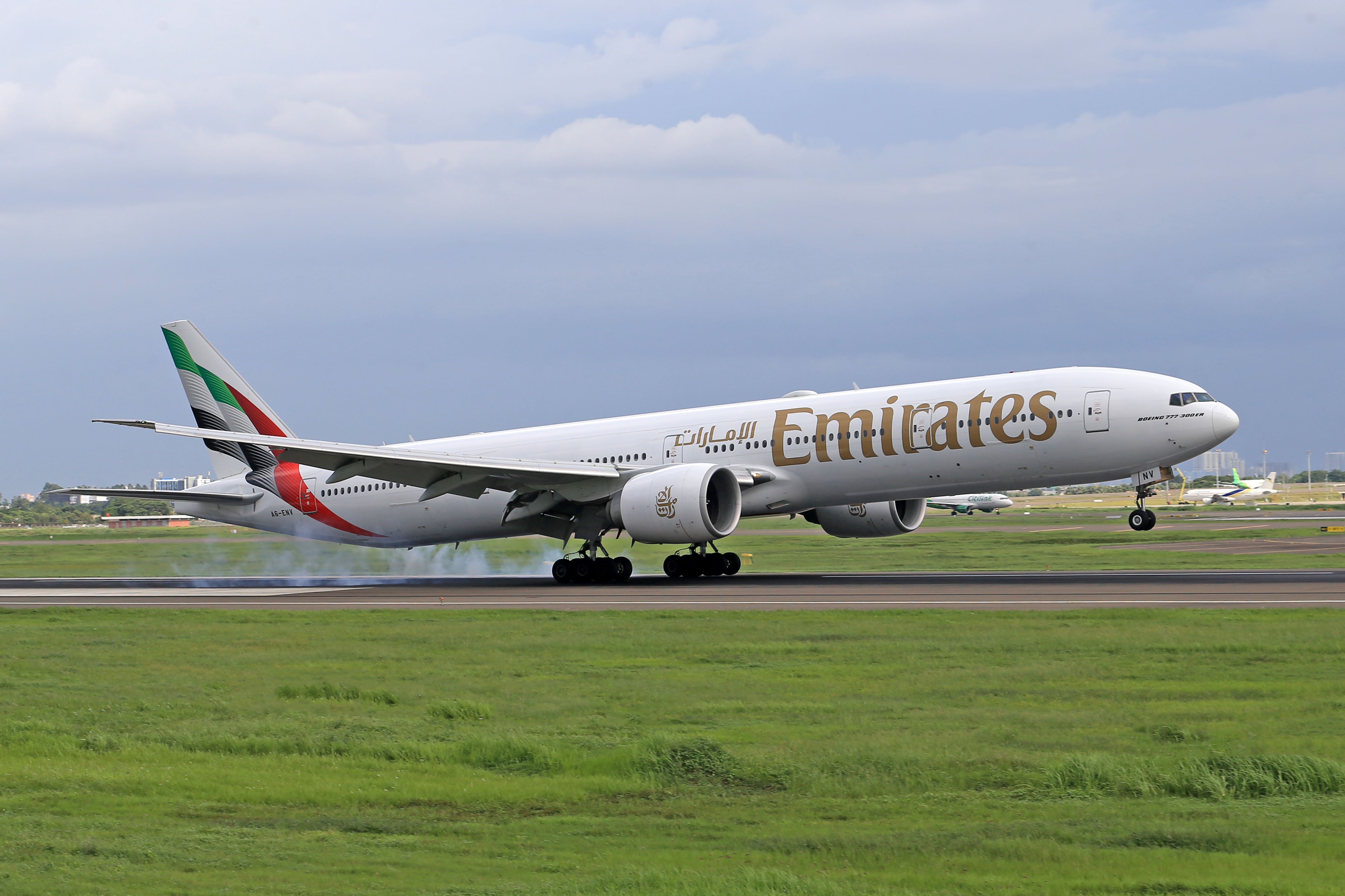 An emirates airplane taking off from an airport runway · Free Stock Photo