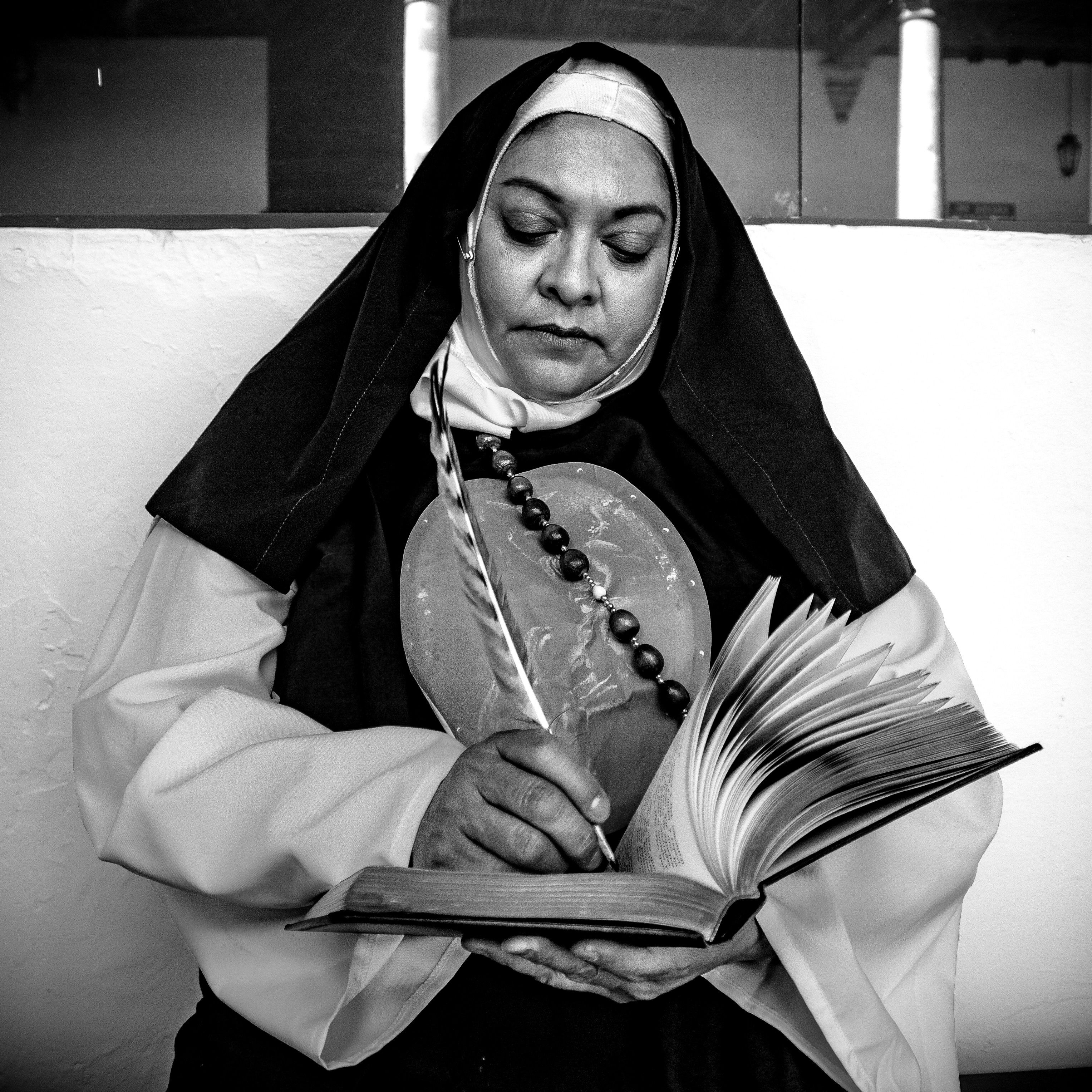 A nun reading a book in black and white · Free Stock Photo