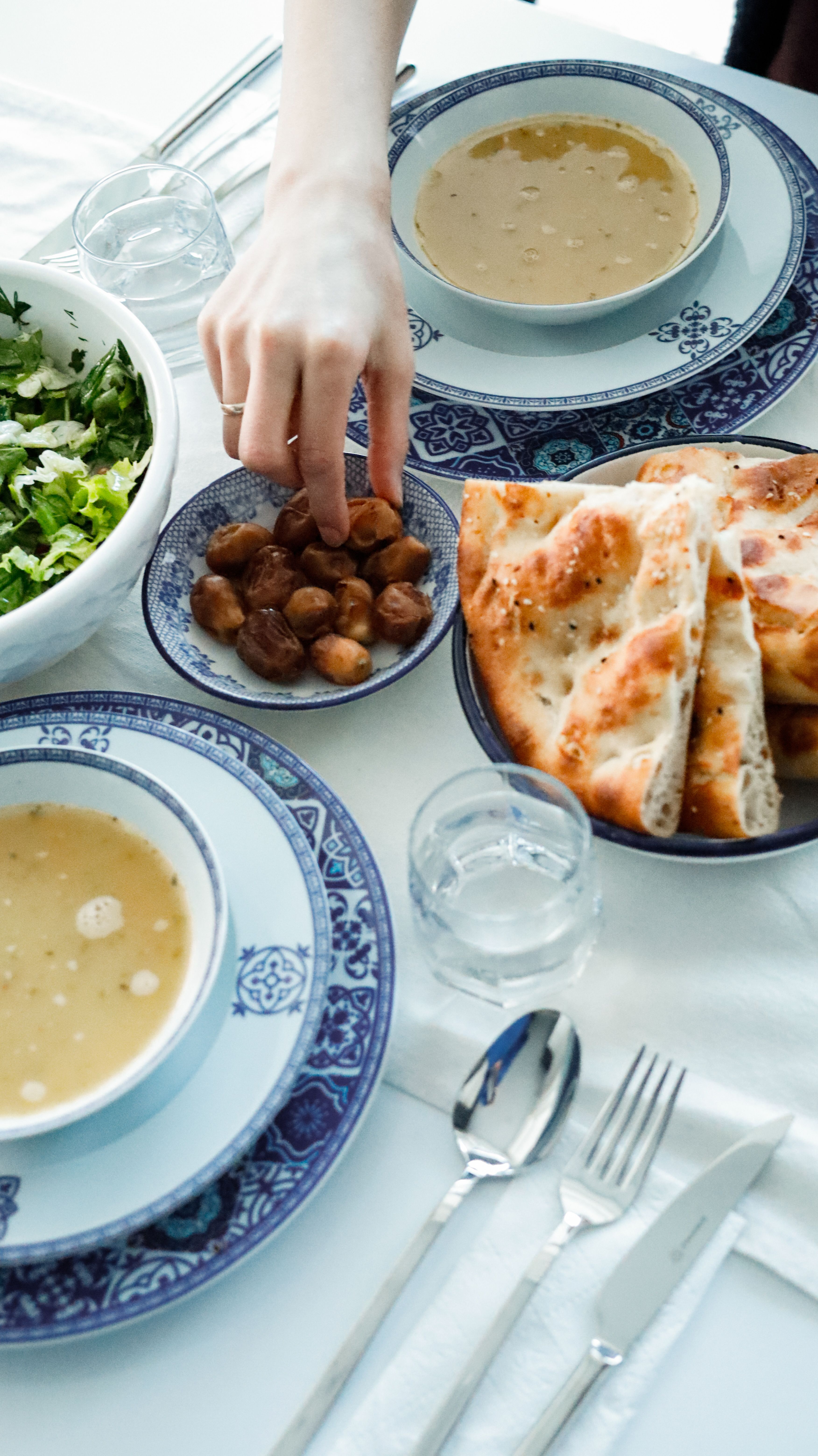 Close-up of a Person Taking Food from a Bowl on a Table · Free Stock Photo