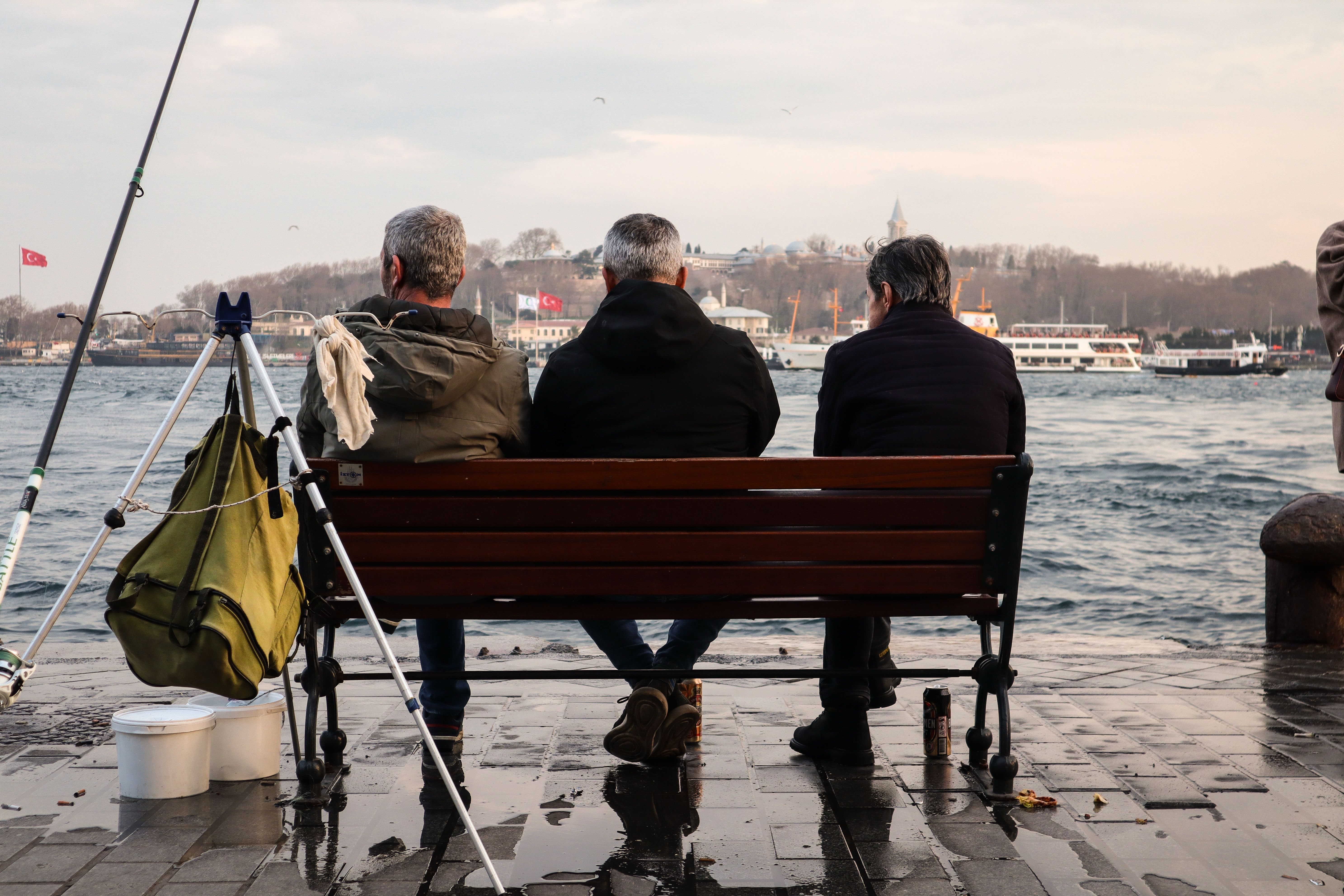 Three men sitting on a bench · Free Stock Photo