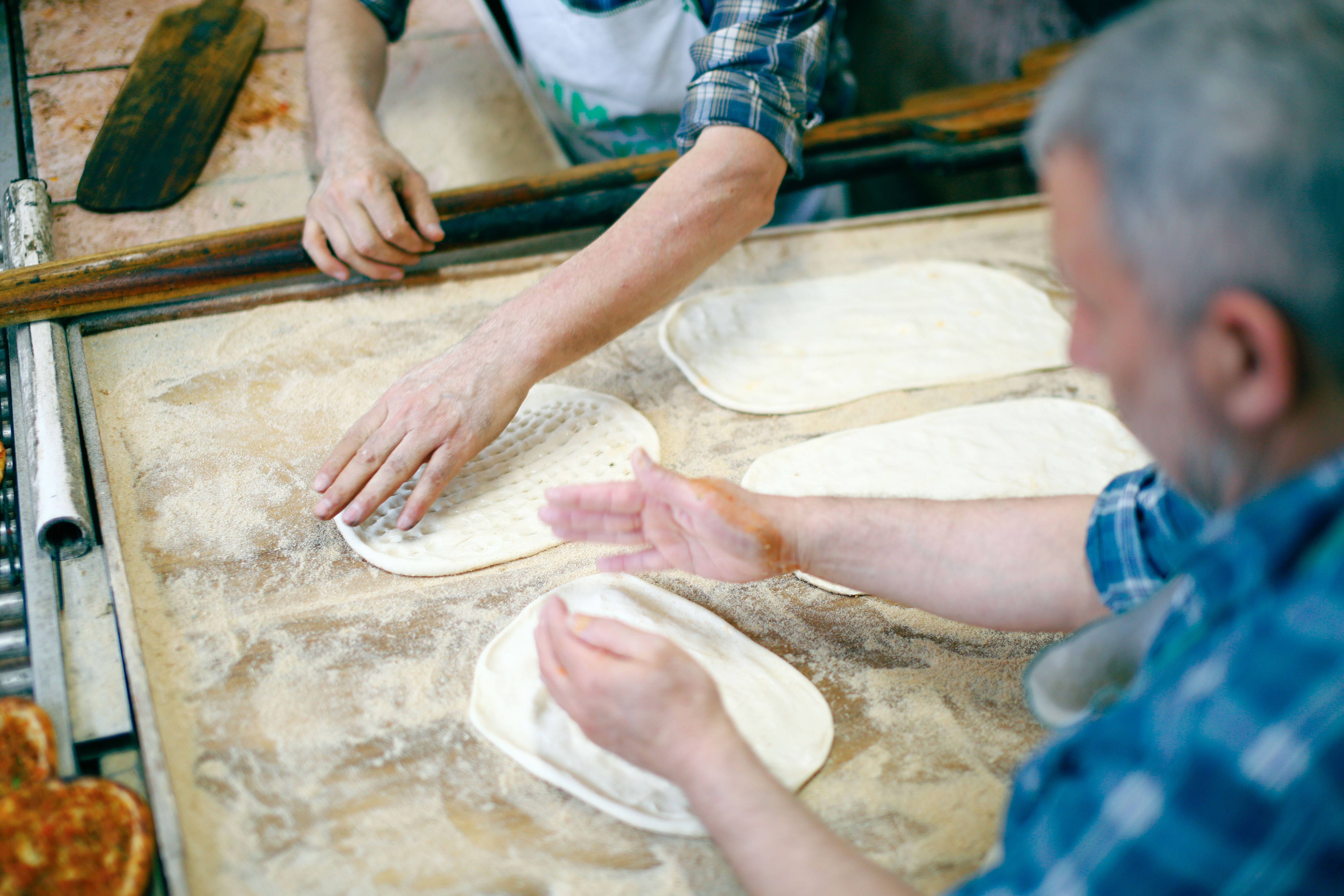 Two men are making dough in a kitchen · Free Stock Photo