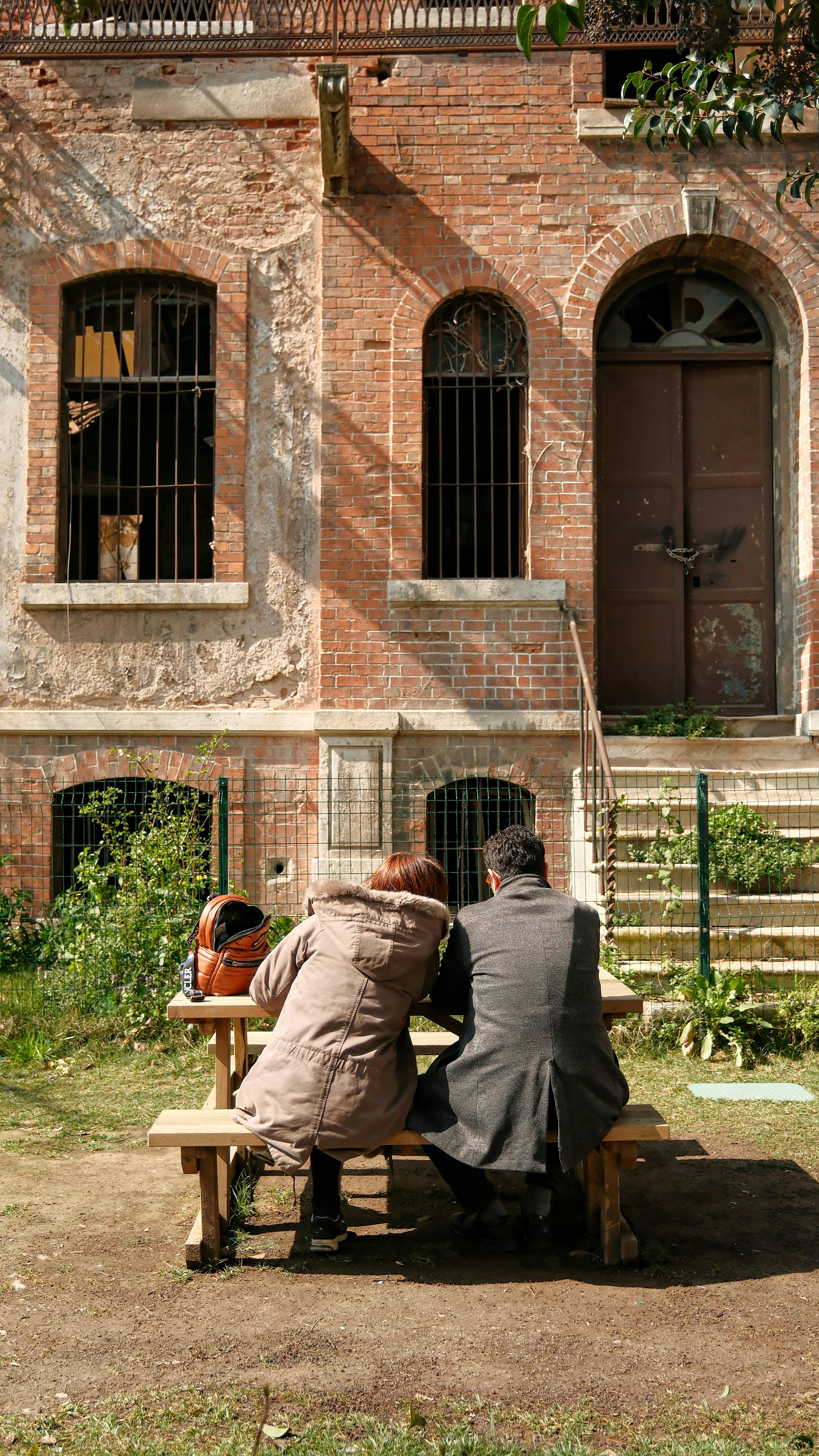 Woman and Man Sitting by Table near Building · Free Stock Photo