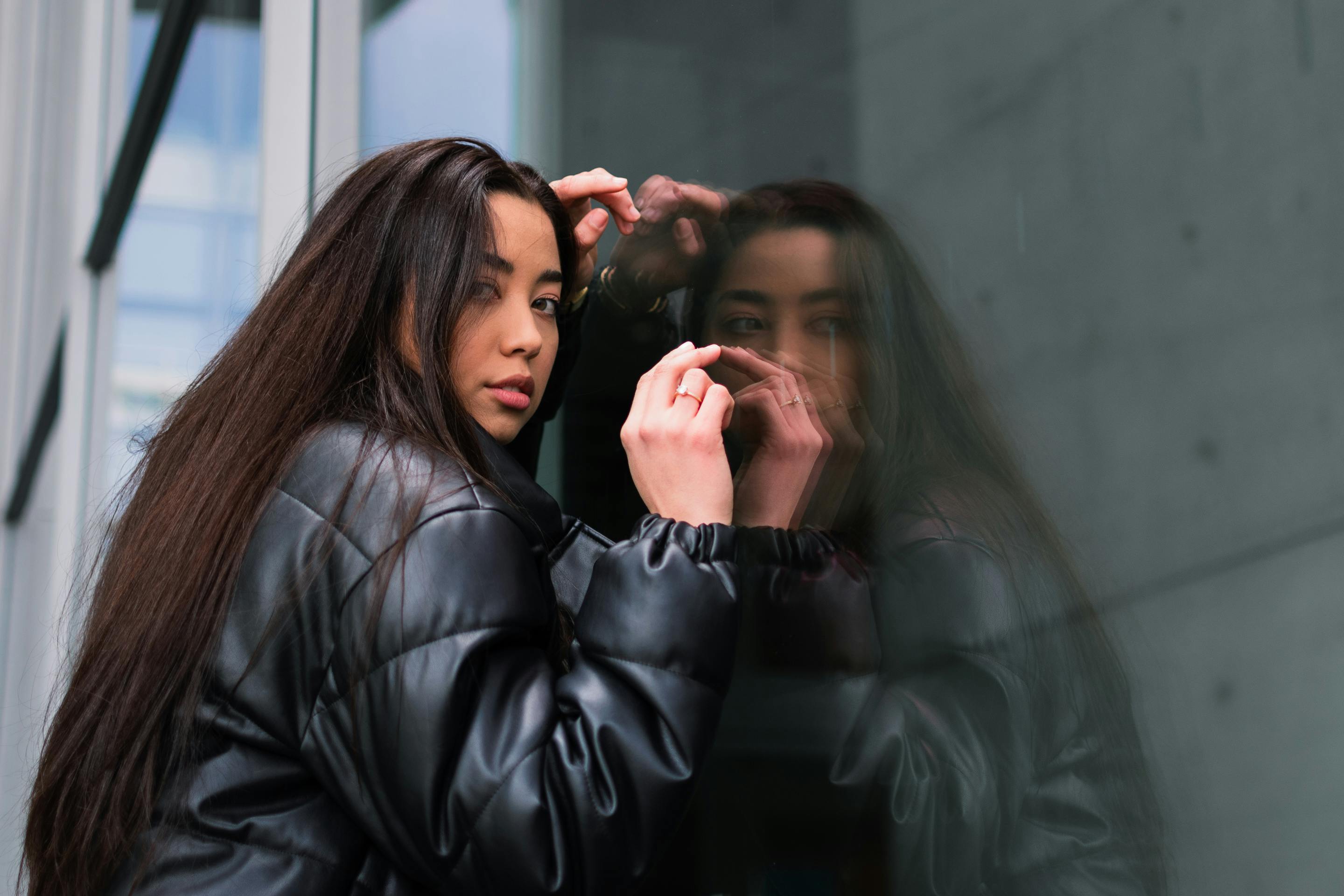 Woman Posing against Reflective Glass Panel · Free Stock Photo
