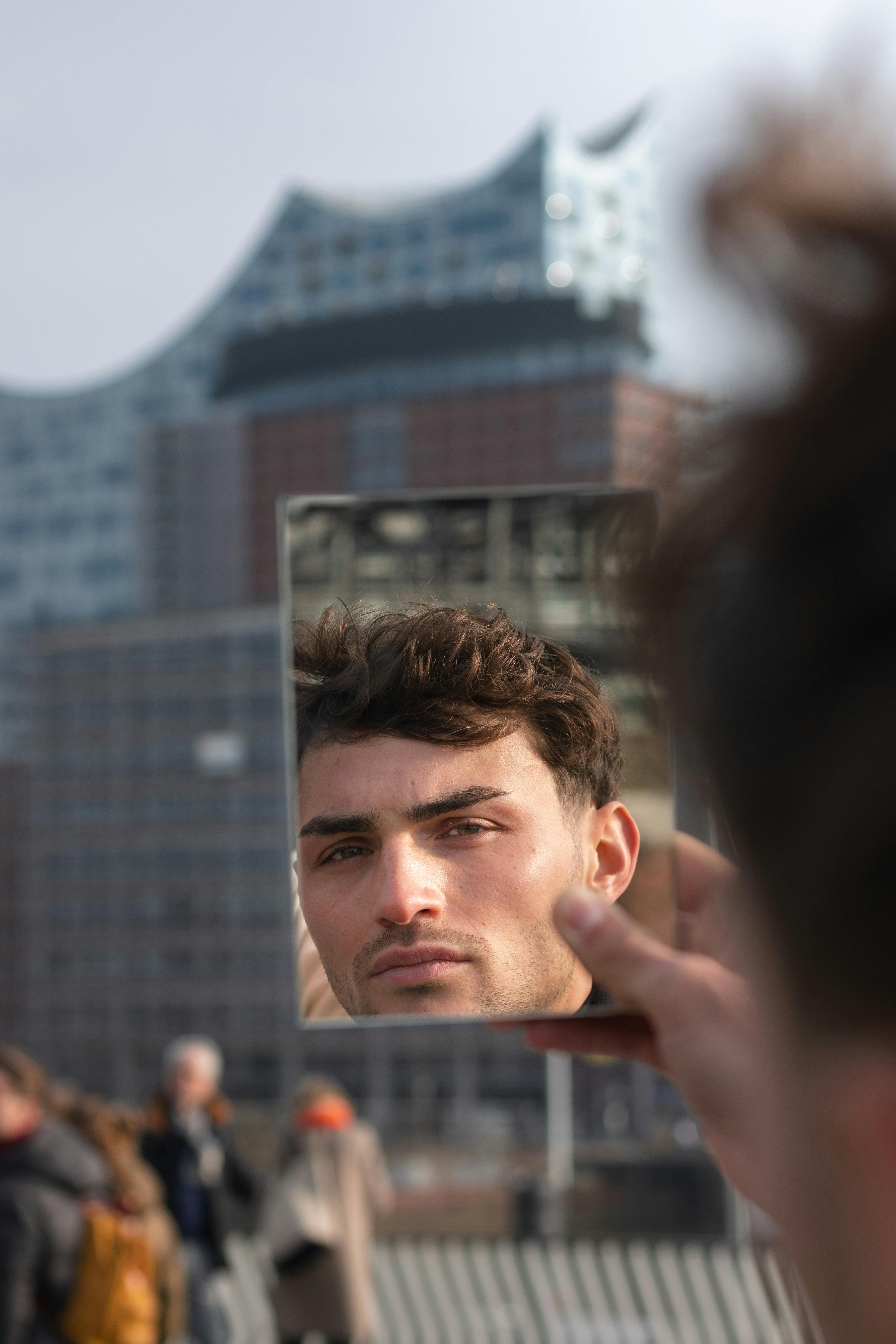 Man Staring at his Reflection in Mirror · Free Stock Photo