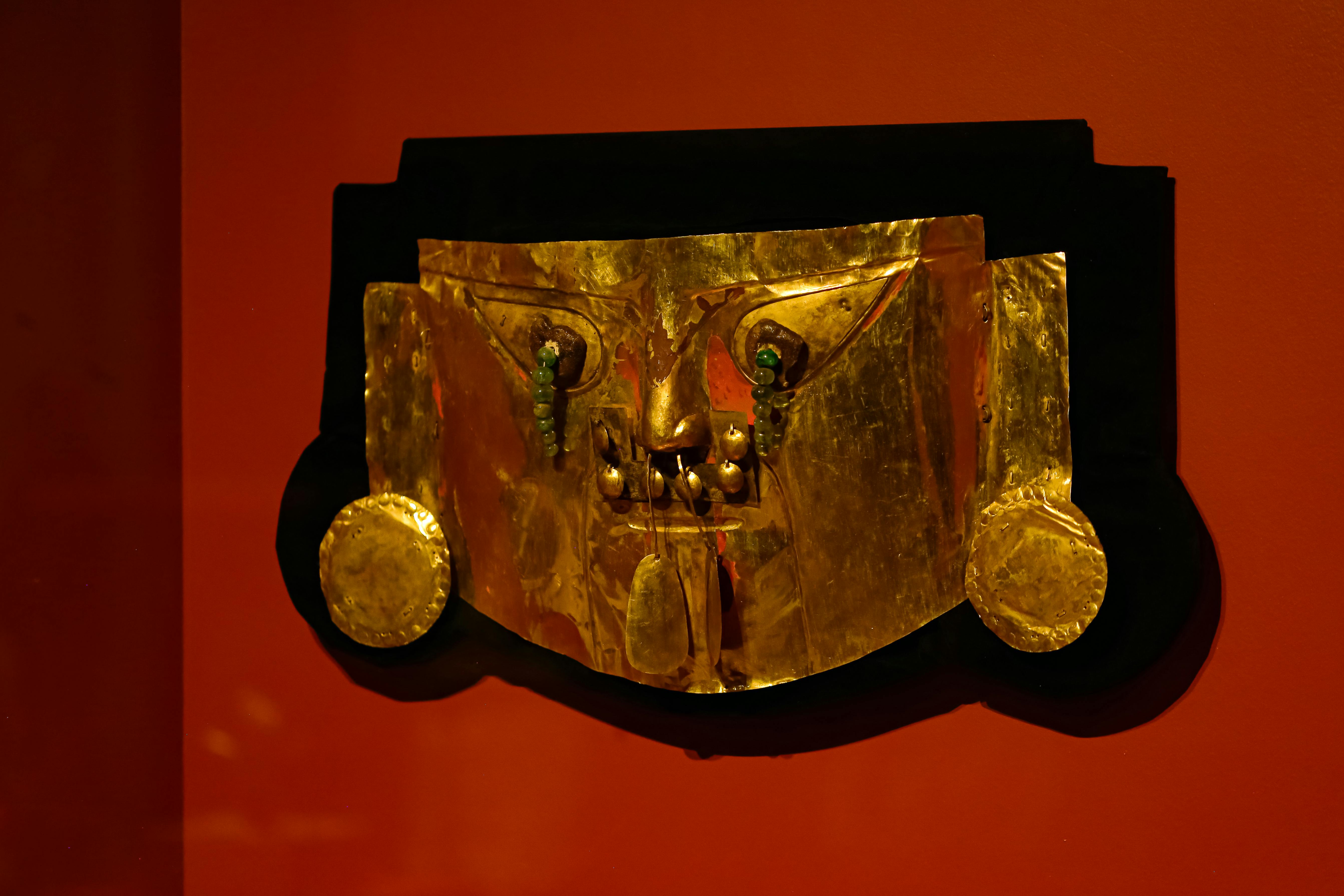 Gold Plated Mask on Display on Red Wall · Free Stock Photo
