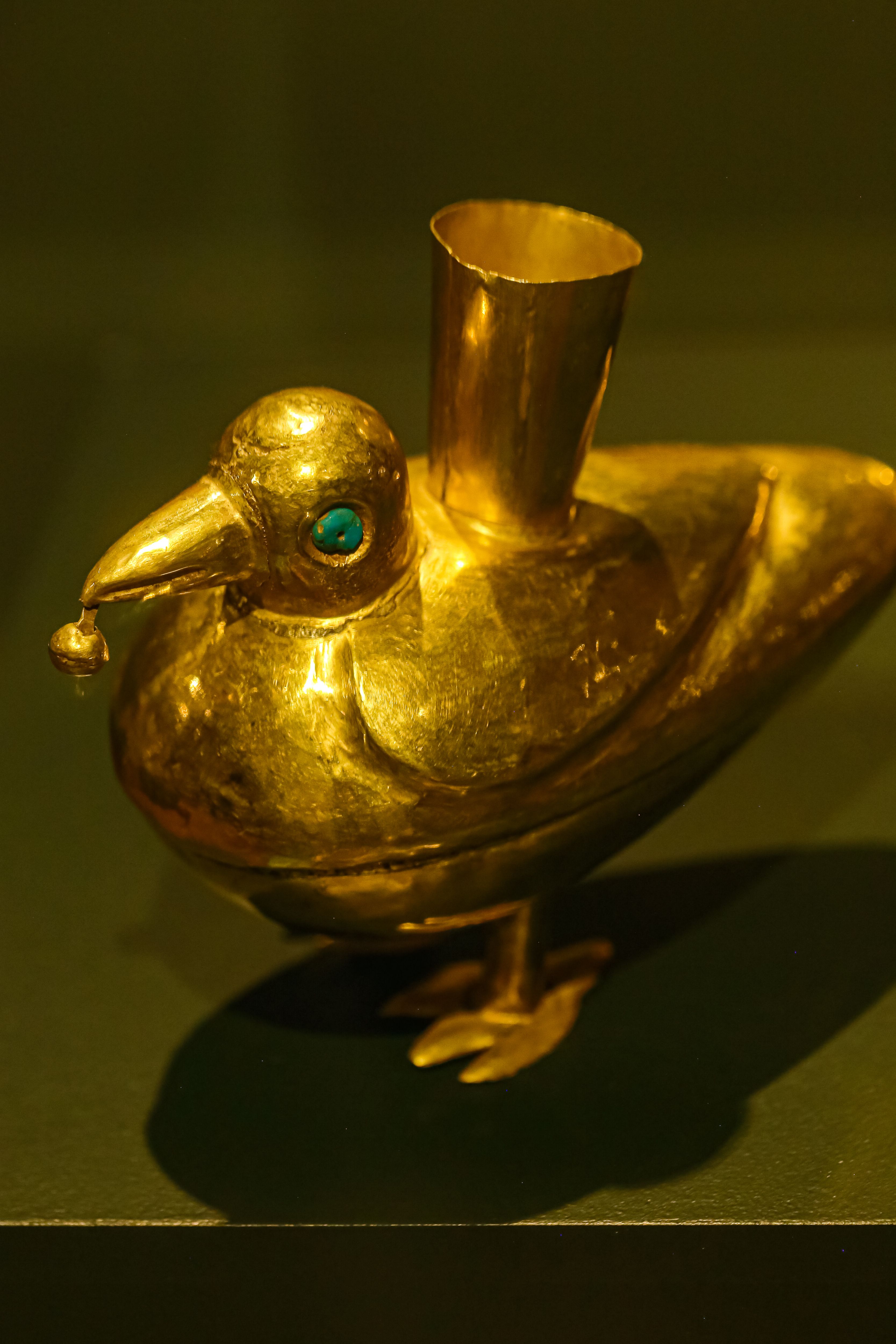 A gold bird with blue eyes on display · Free Stock Photo