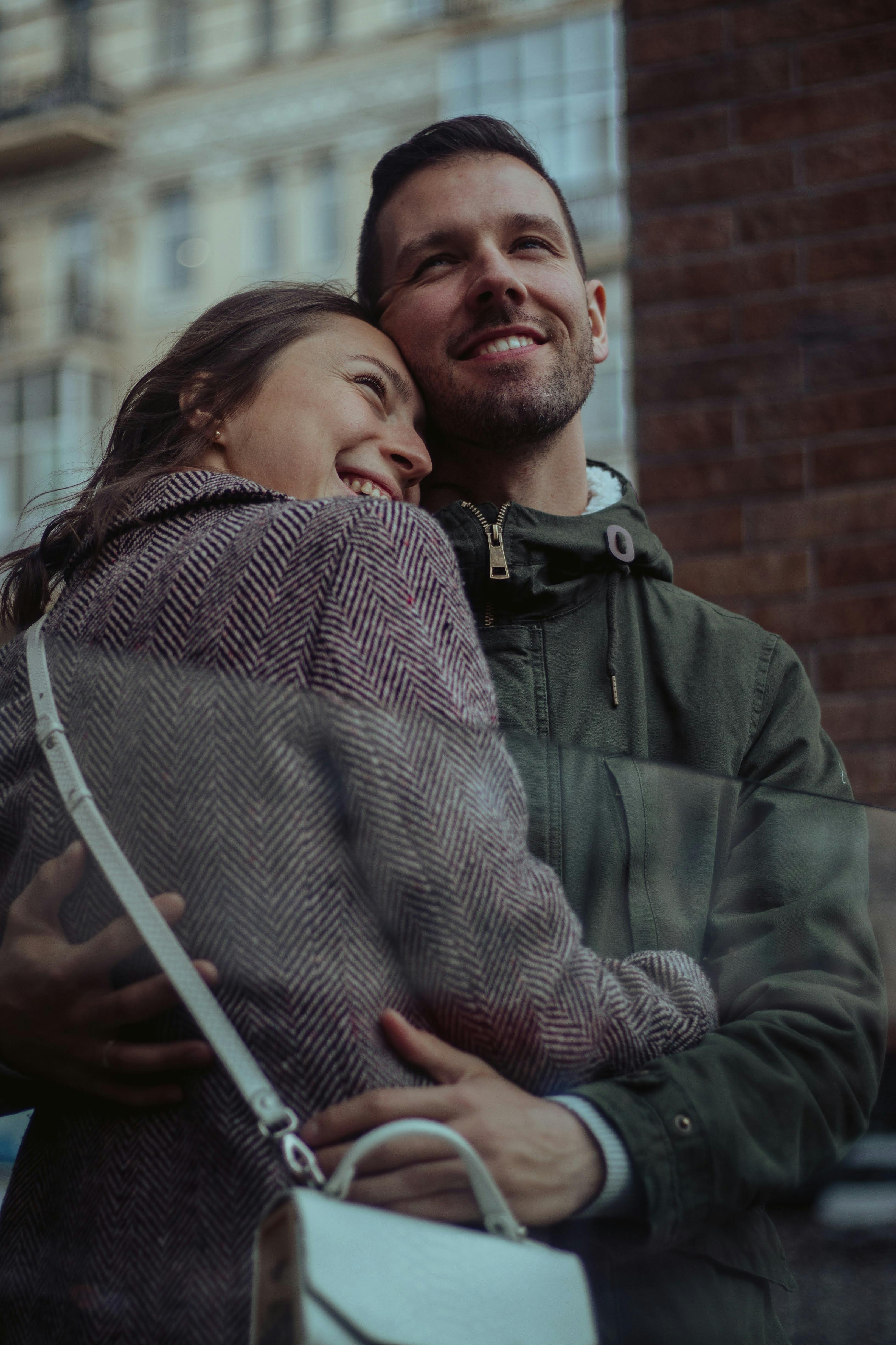 Couple in Jackets Embracing on Street in City · Free Stock Photo