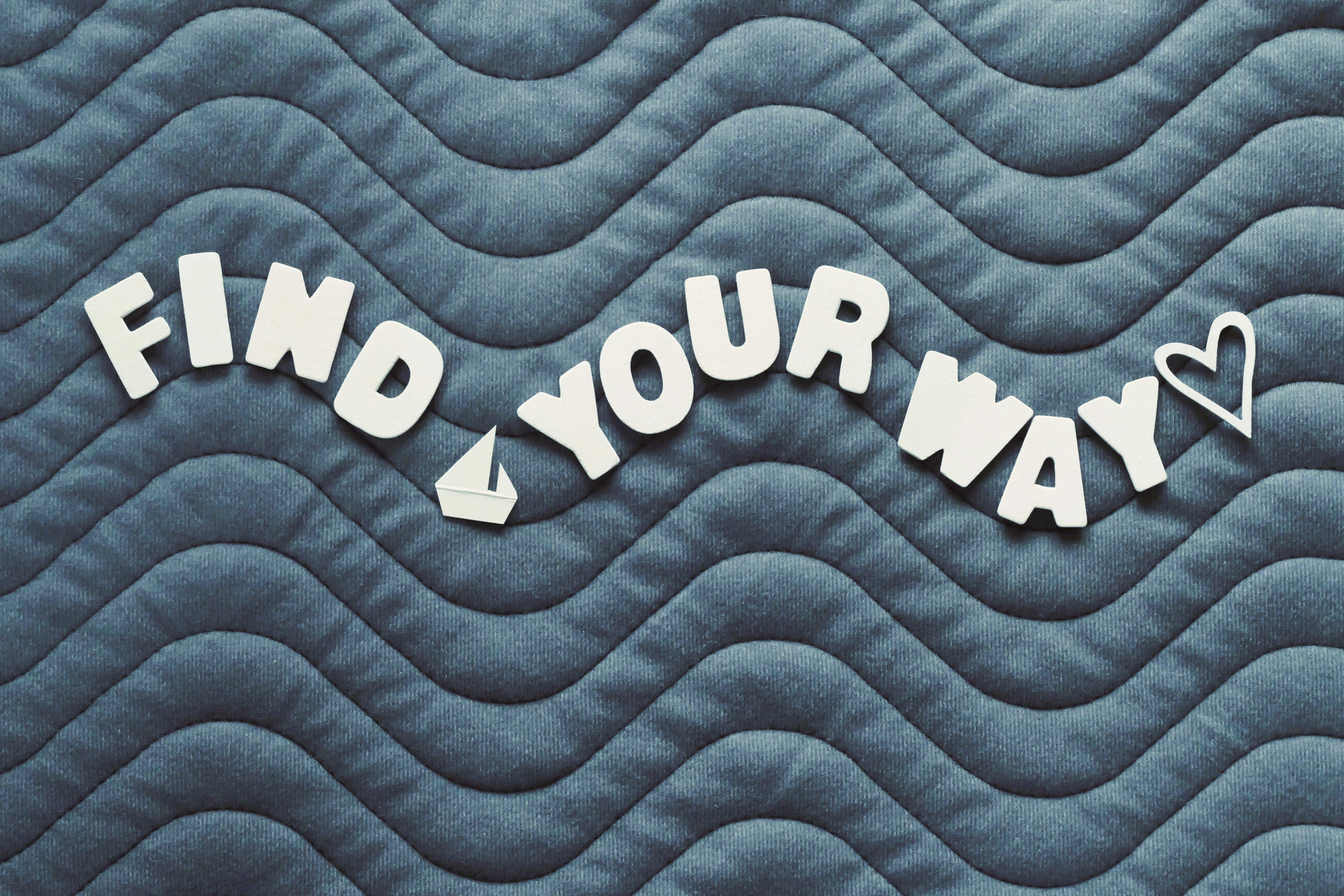 A Text Saying "Find Your Way" Lying on Blue Wavy Fabric · Free Stock Photo