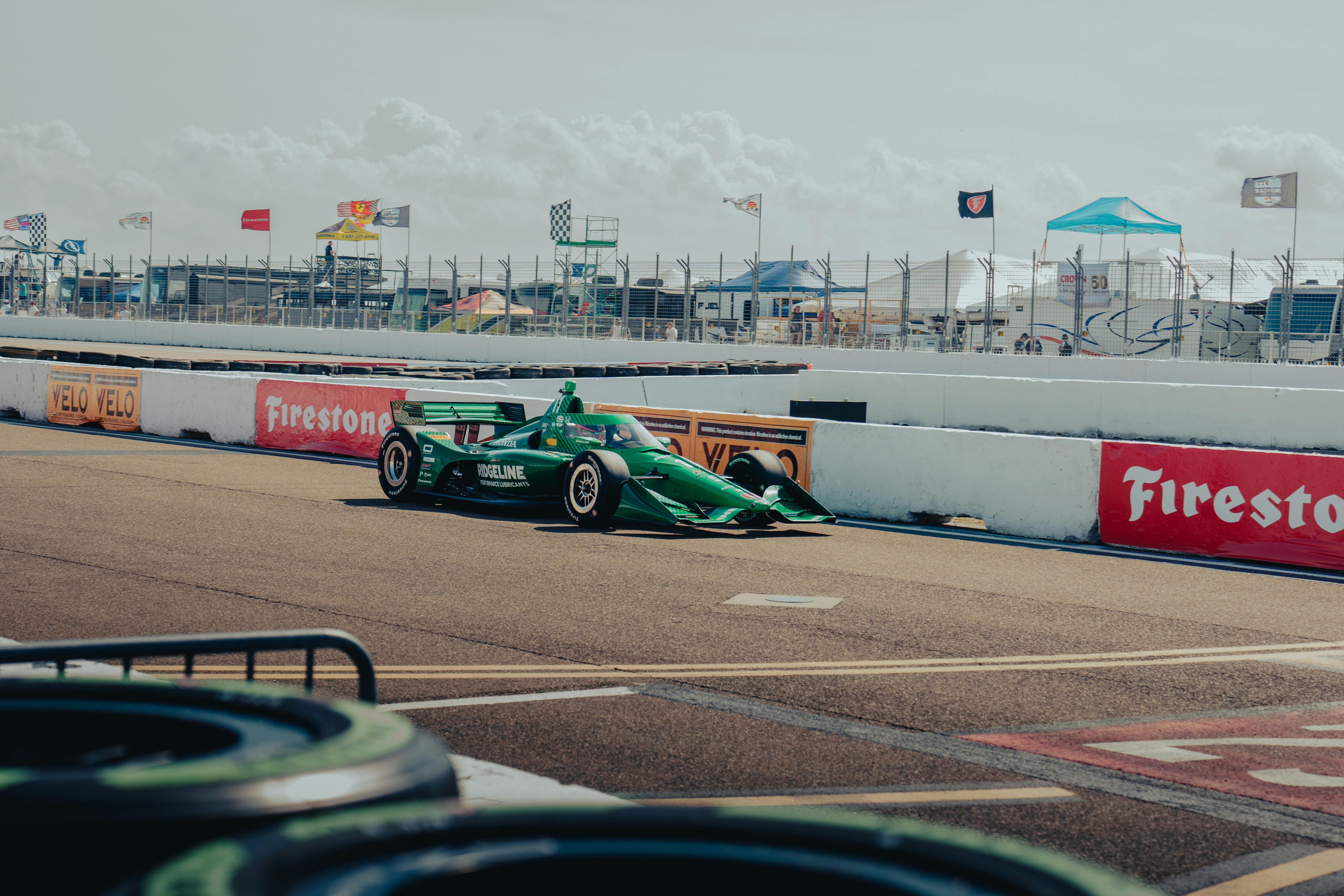 Green Indycar Standing on the Racetrack · Free Stock Photo