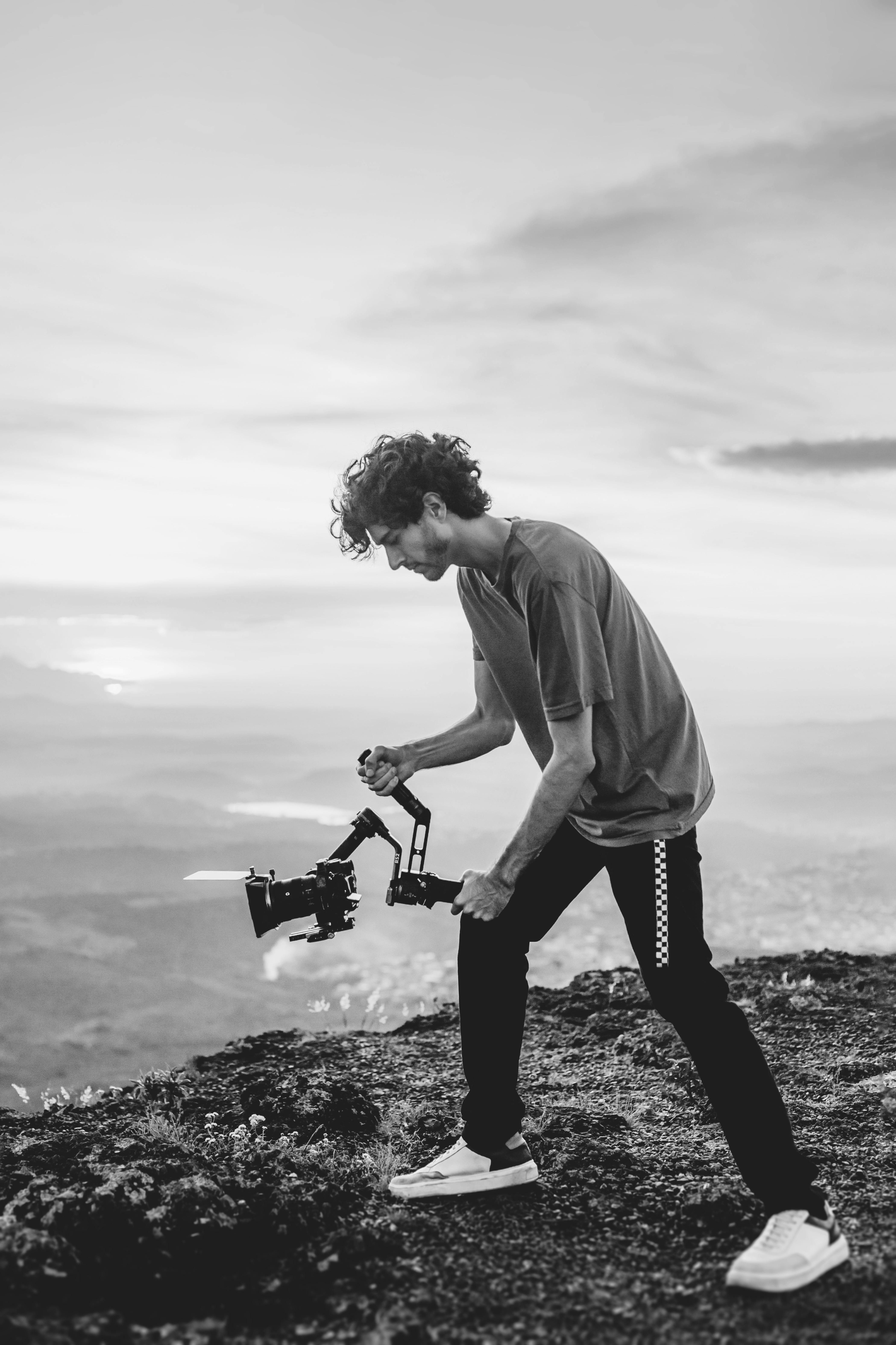 Man Standing with Camera and Filming on Hilltop · Free Stock Photo