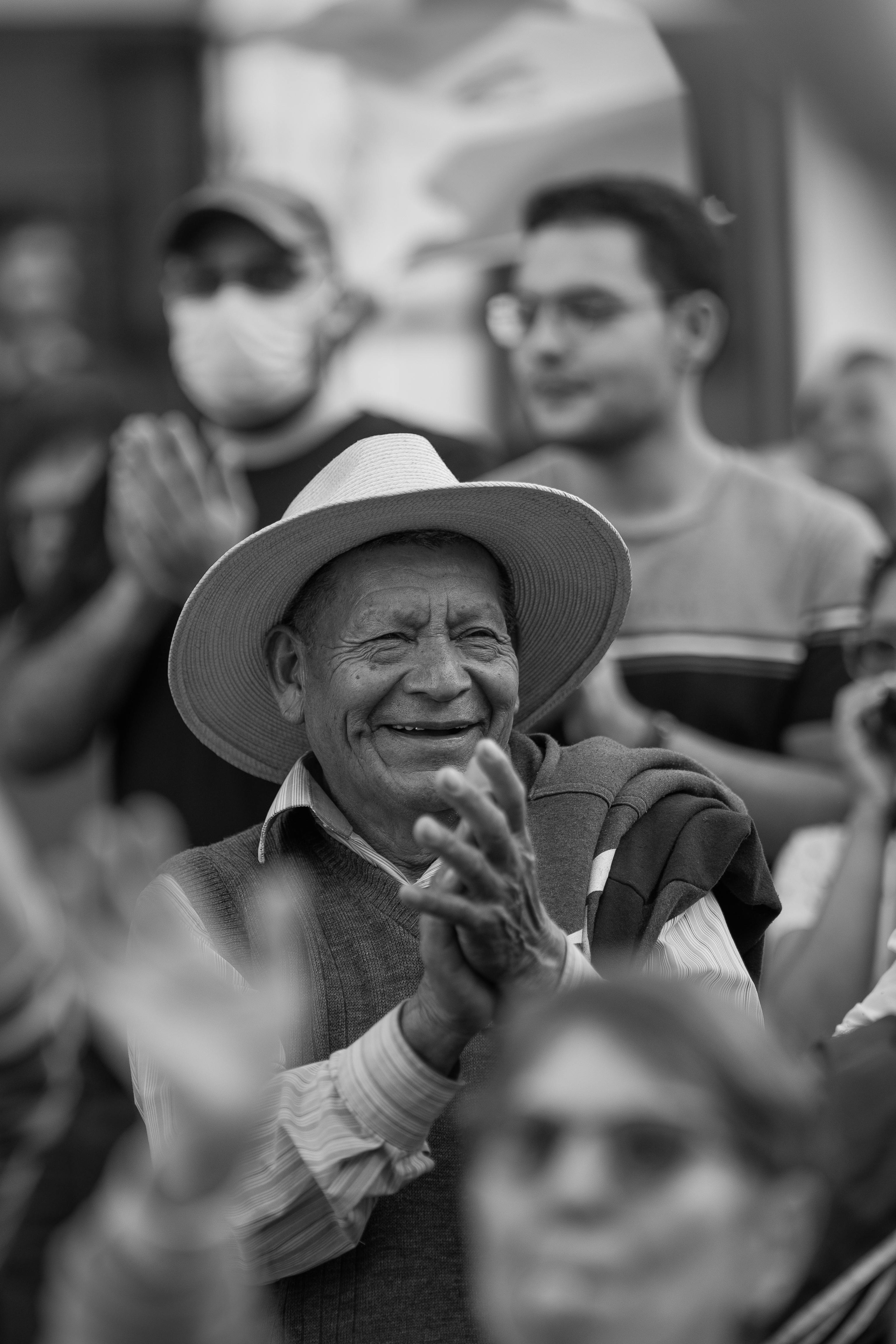 Smiling Man in Hat Clapping Hands among People · Free Stock Photo