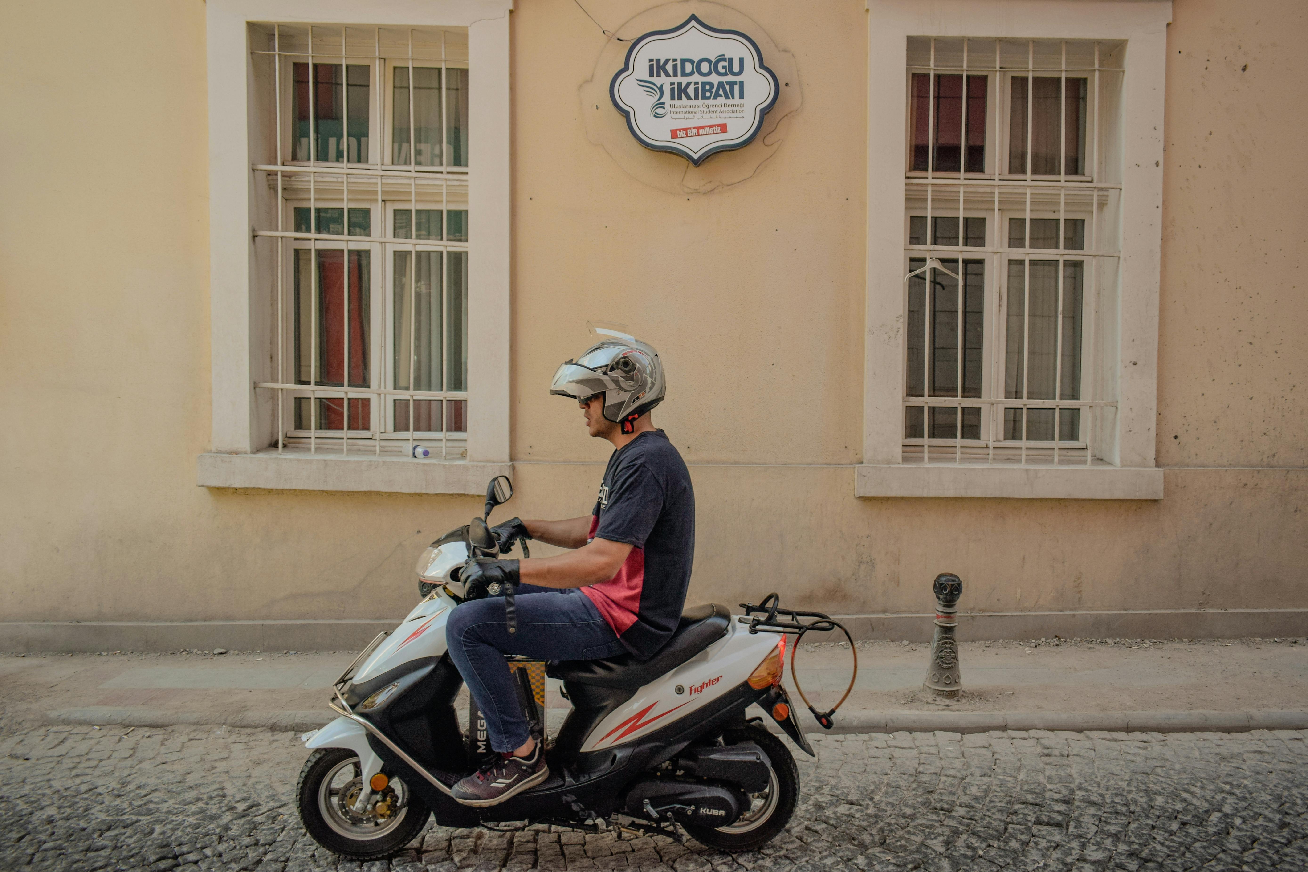 Man in Helmet Riding Motor Scooter on Street · Free Stock Photo