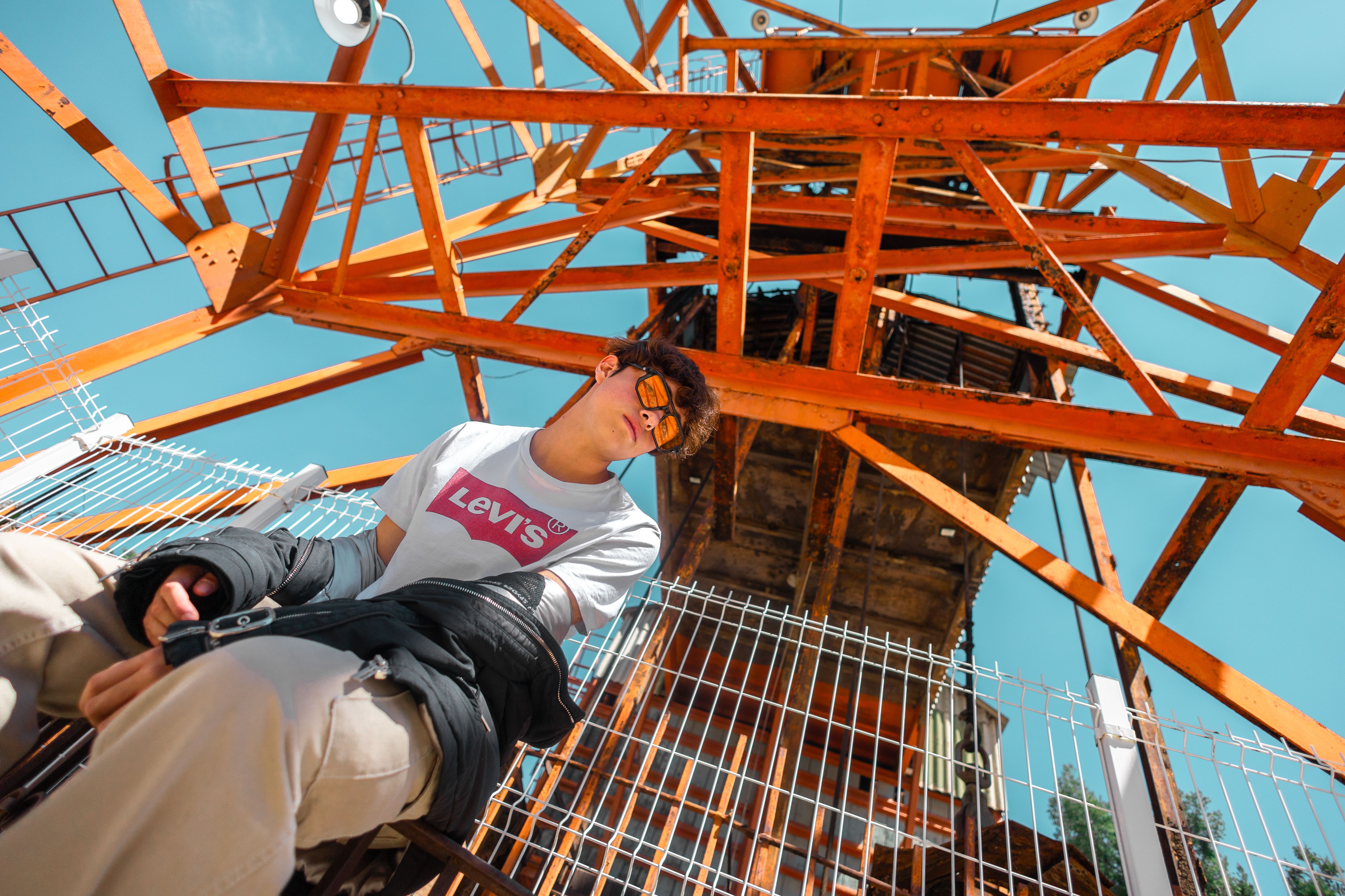 Man in T-shirt and Jacket Sitting under Construction Beams · Free Stock ...