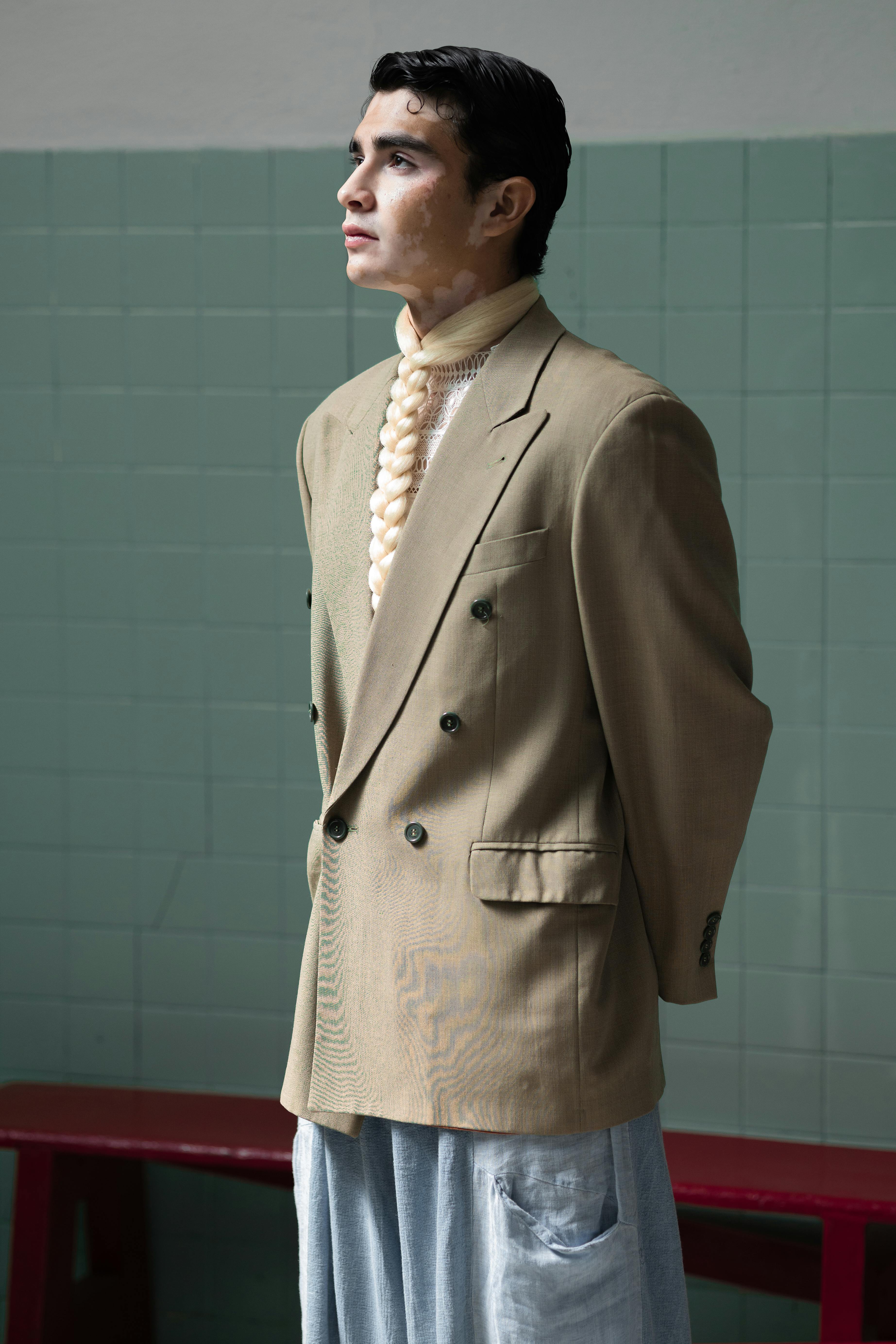 A man in a suit standing in a locker room · Free Stock Photo