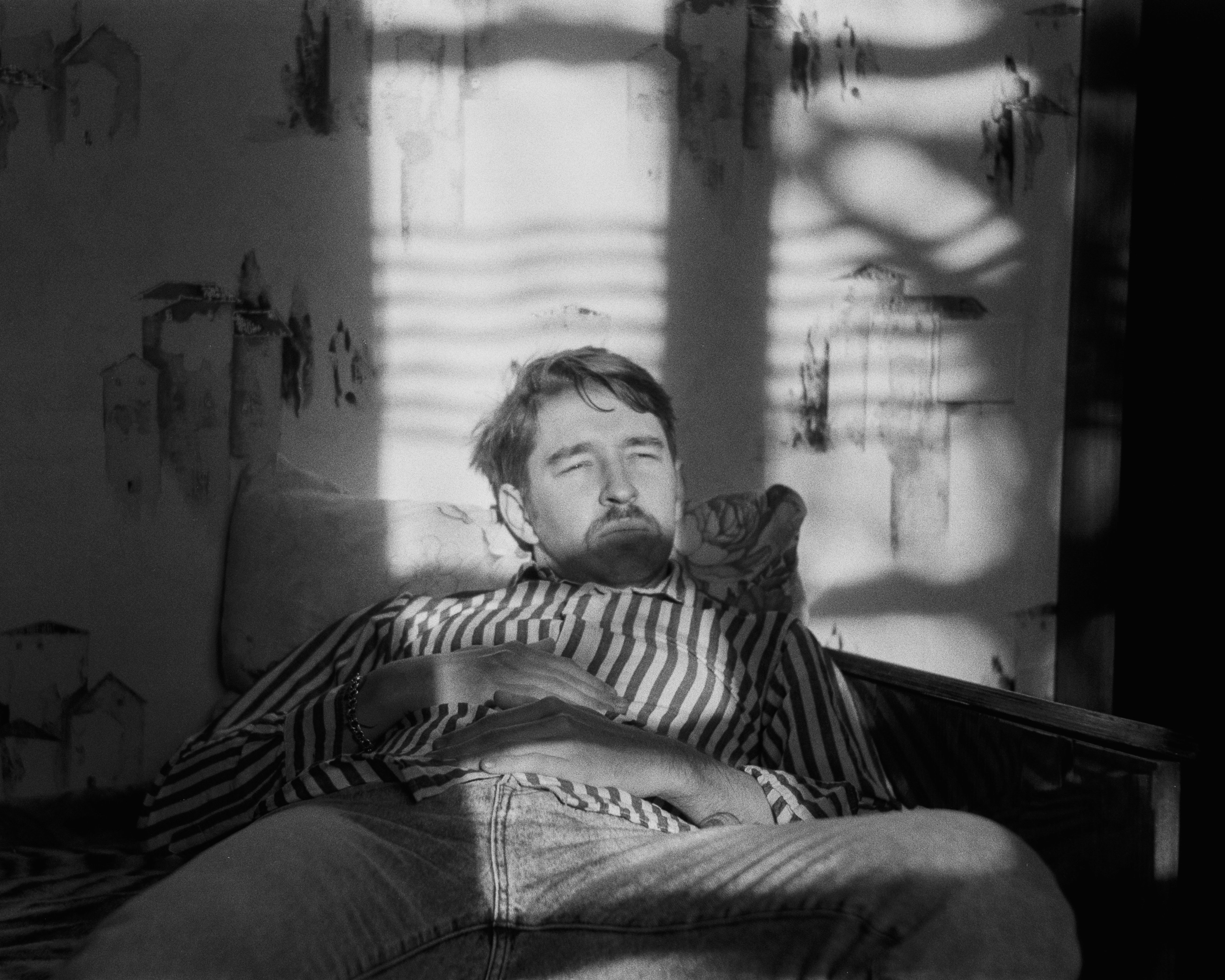 A man laying down on a bed with a blanket · Free Stock Photo