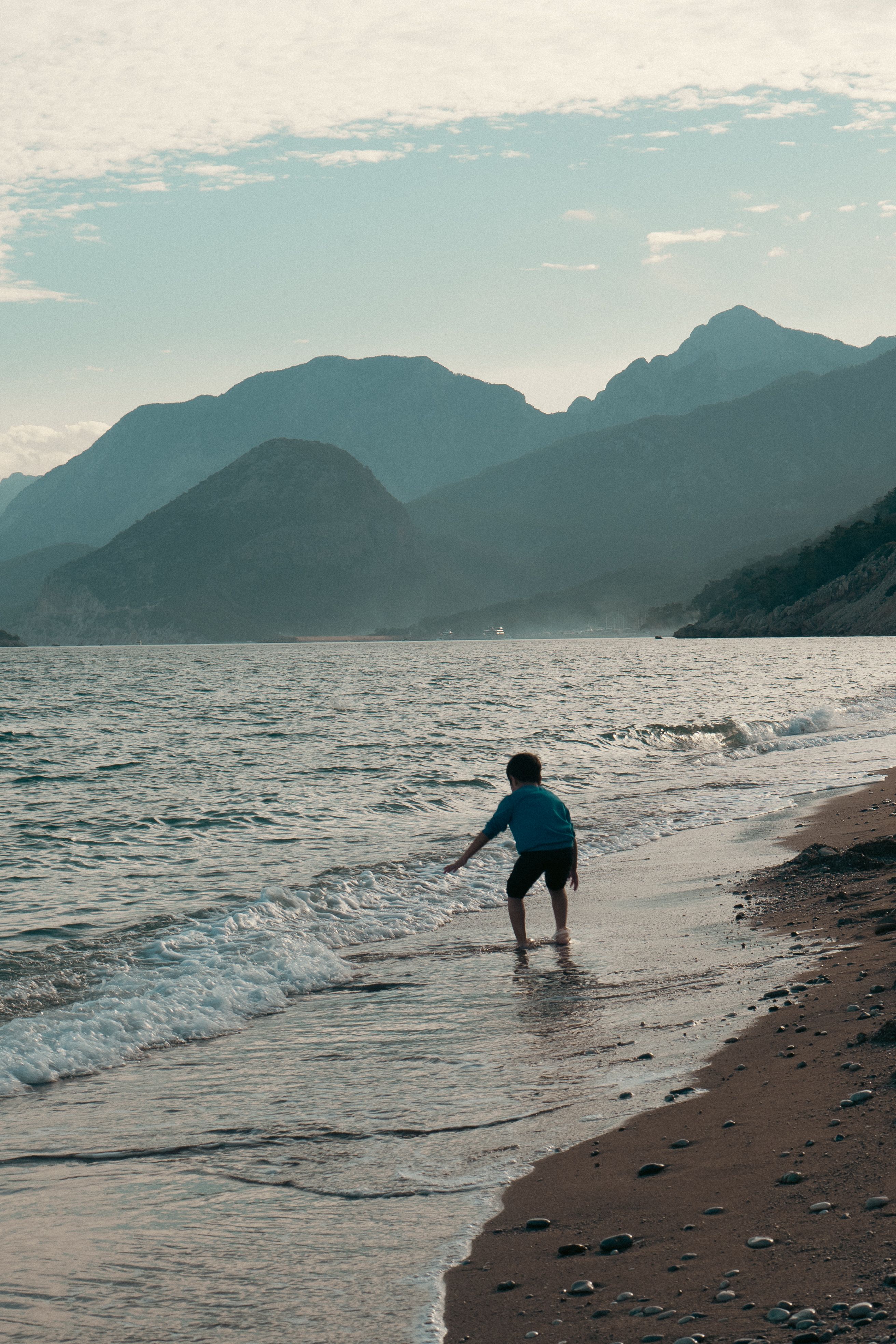 Back View of a Boy Walking on the Beach · Free Stock Photo
