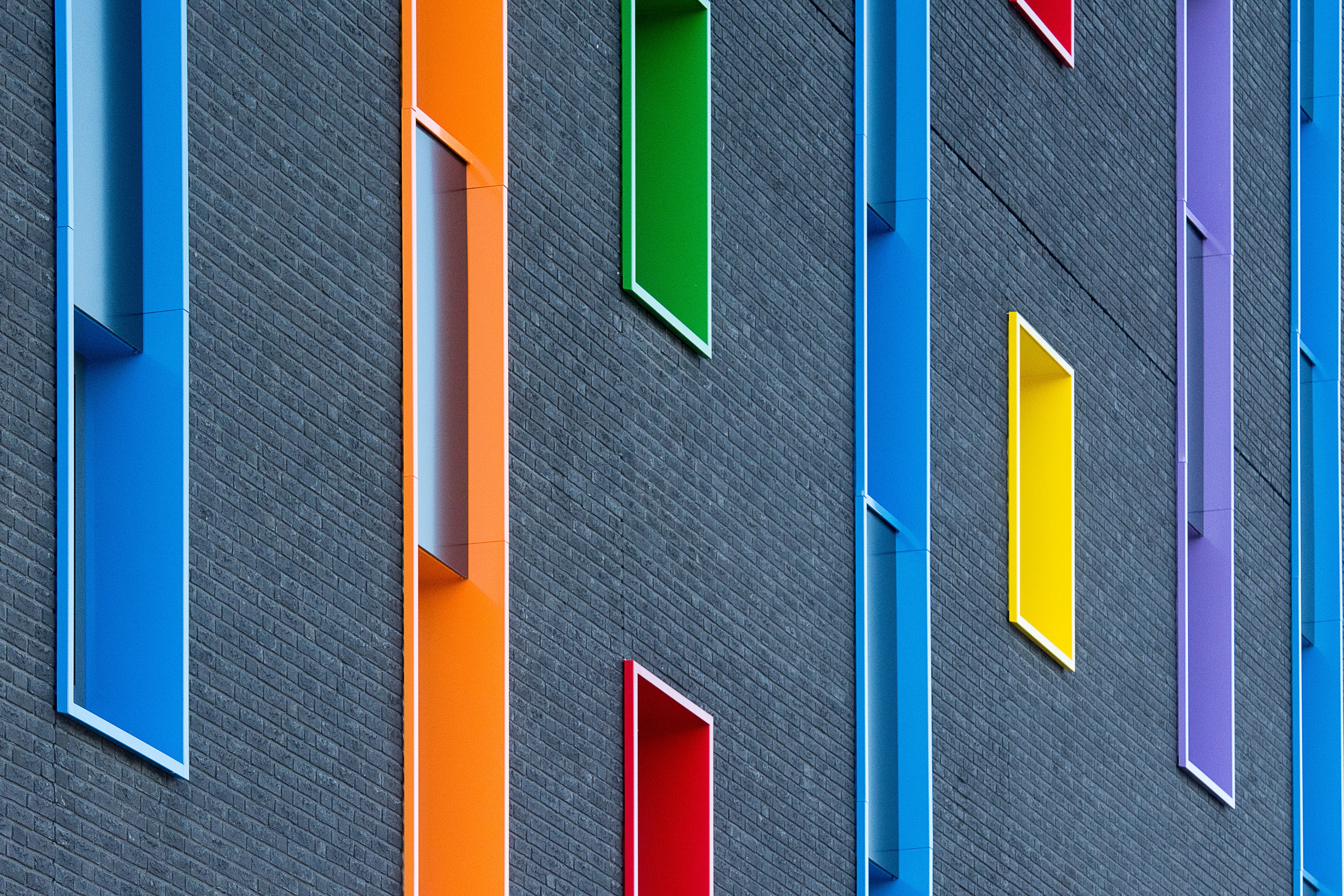 A close up of a building with many different colored windows · Free ...