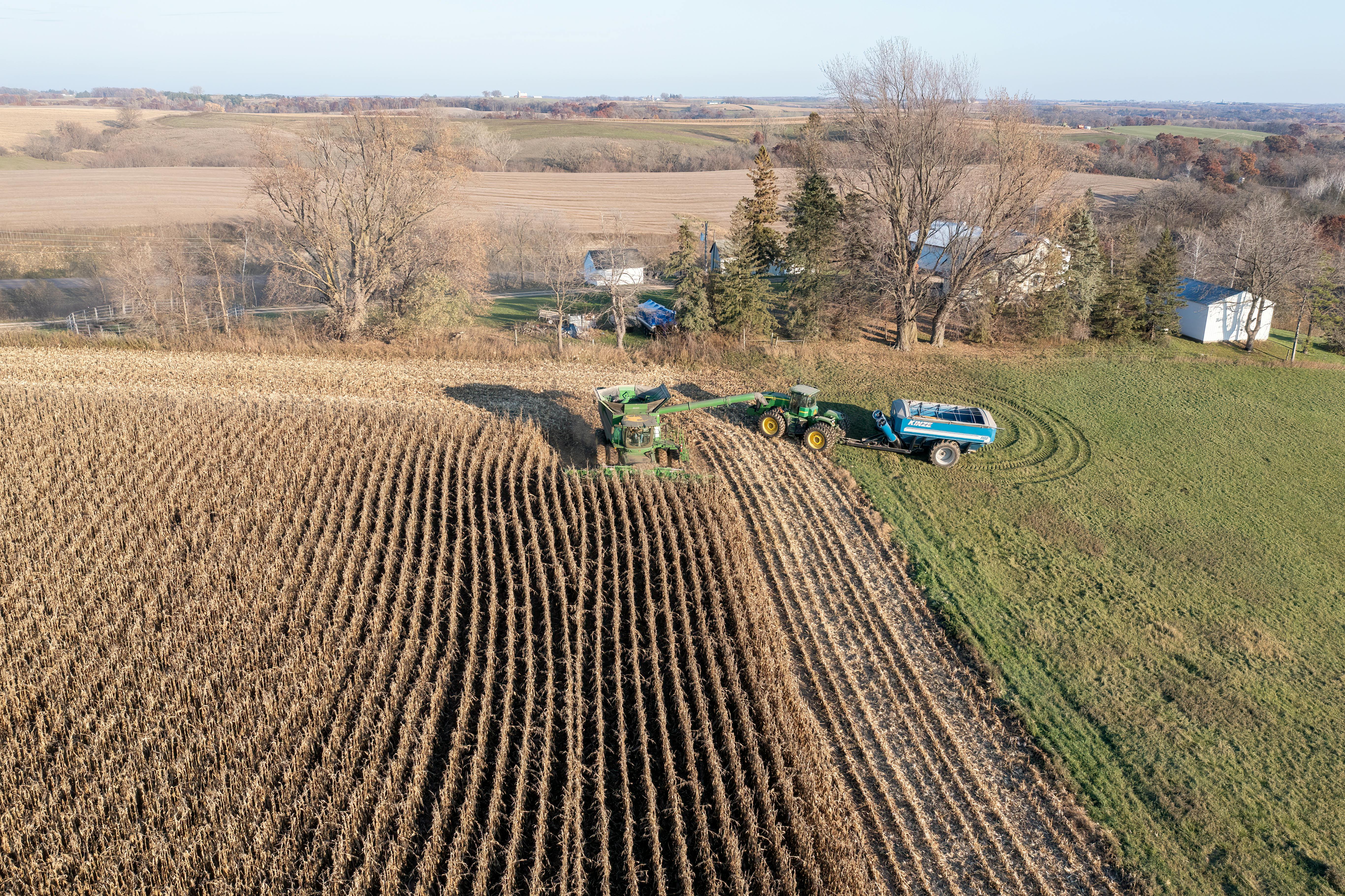Tractor and Harvester Working on Rural Field · Free Stock Photo