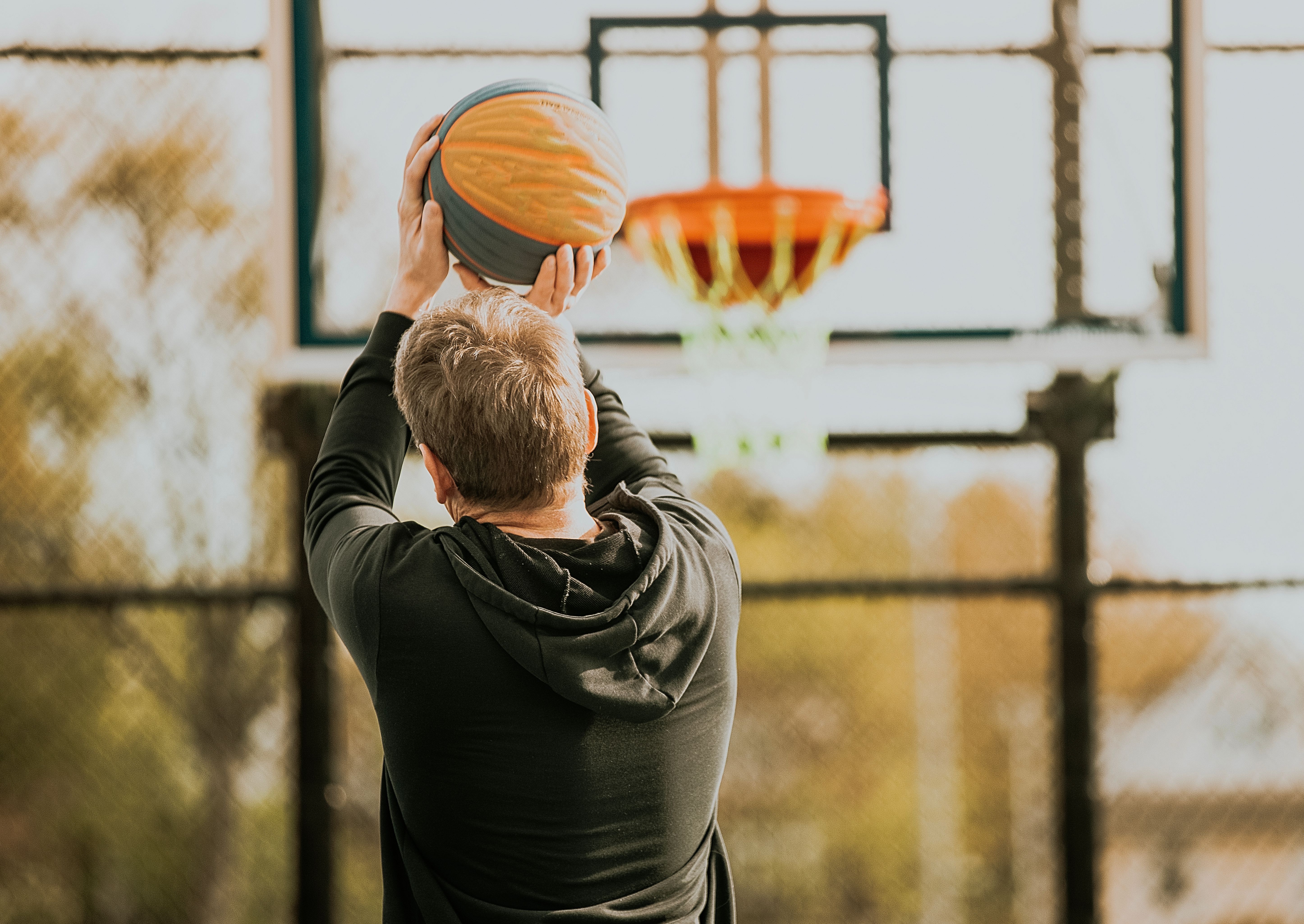 A basketball player puts the ball in the hoop · Free Stock Photo