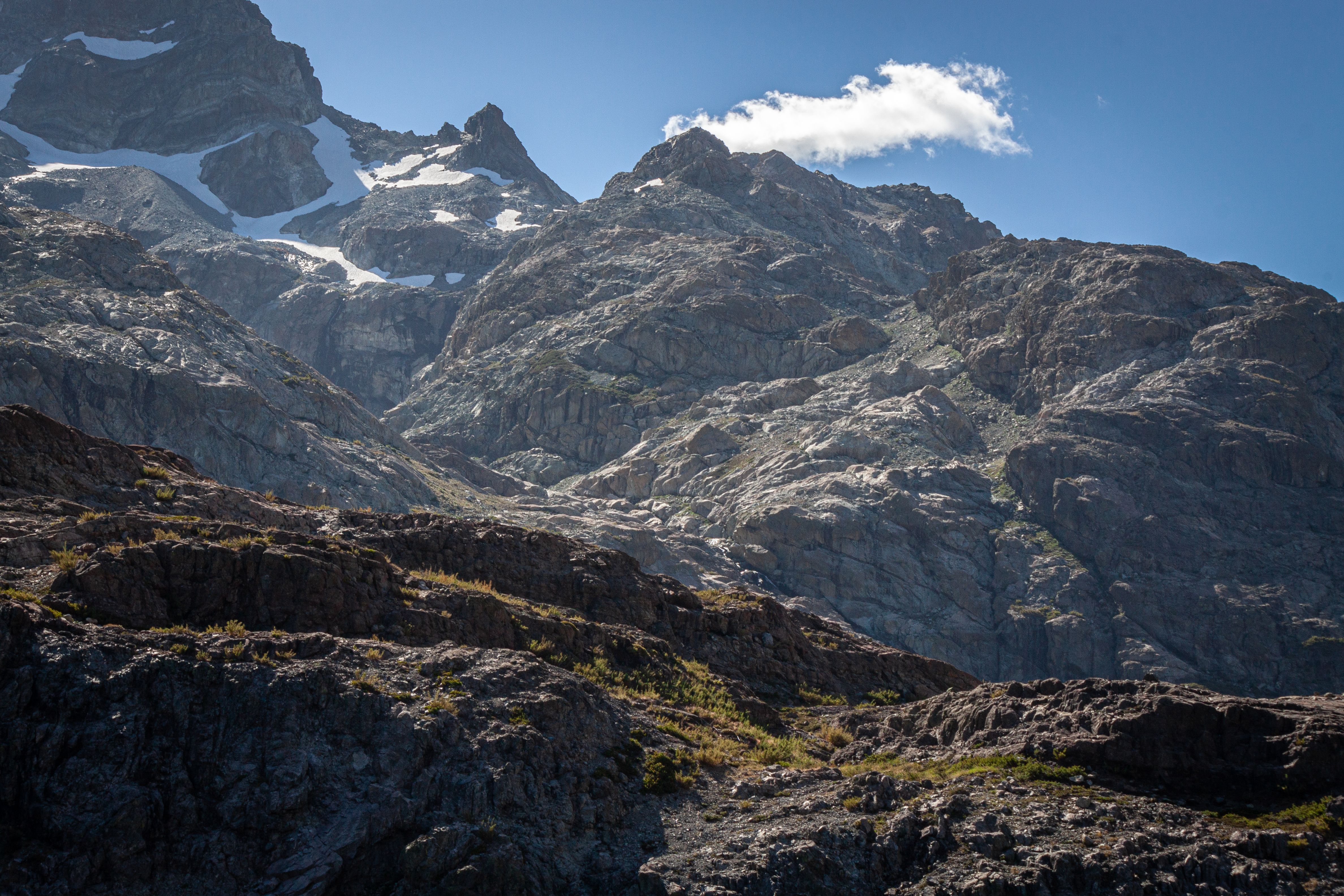A mountain range with a large rock formation · Free Stock Photo