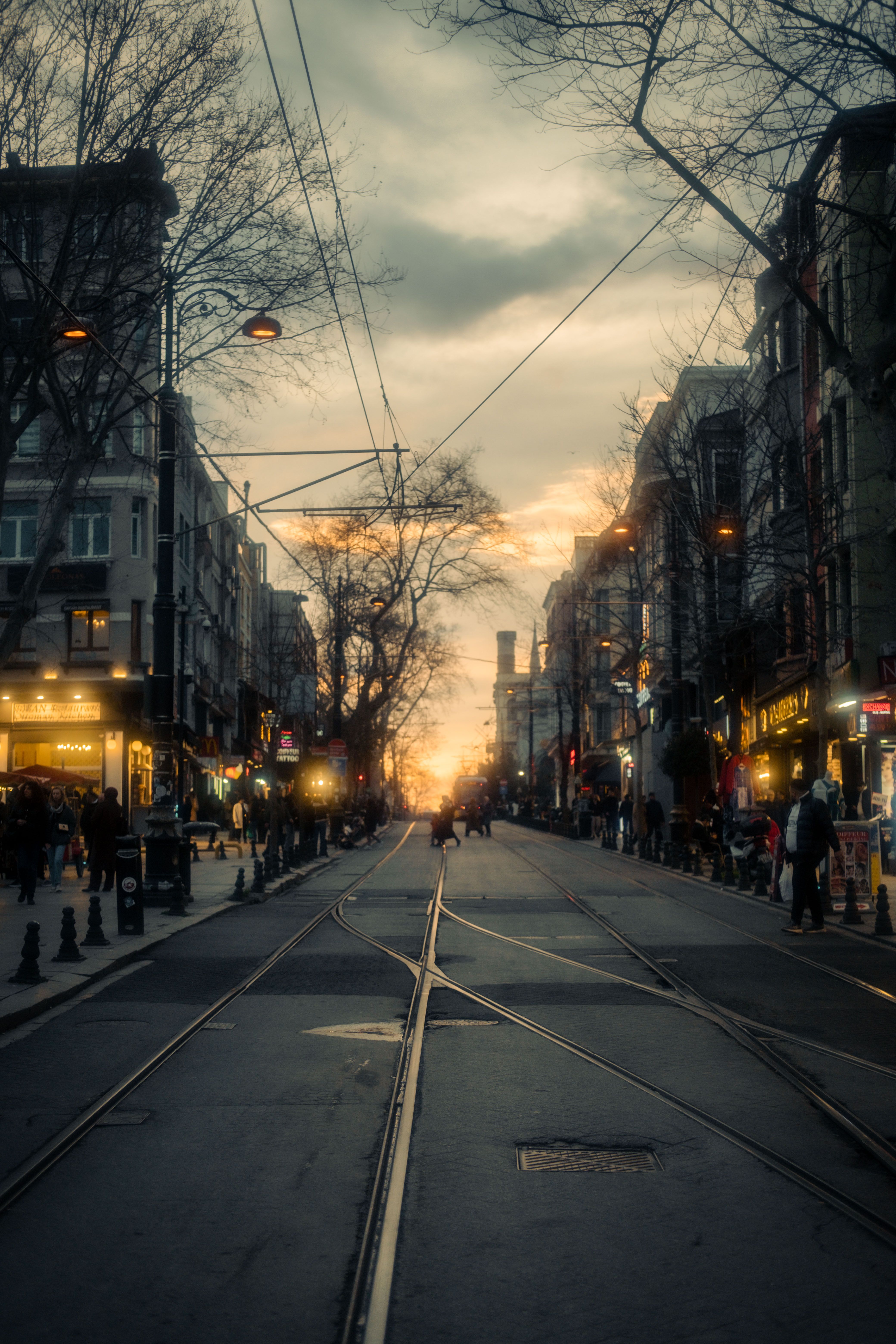 People Walking on Sidewalks along Empty Street at Sunset · Free Stock Photo