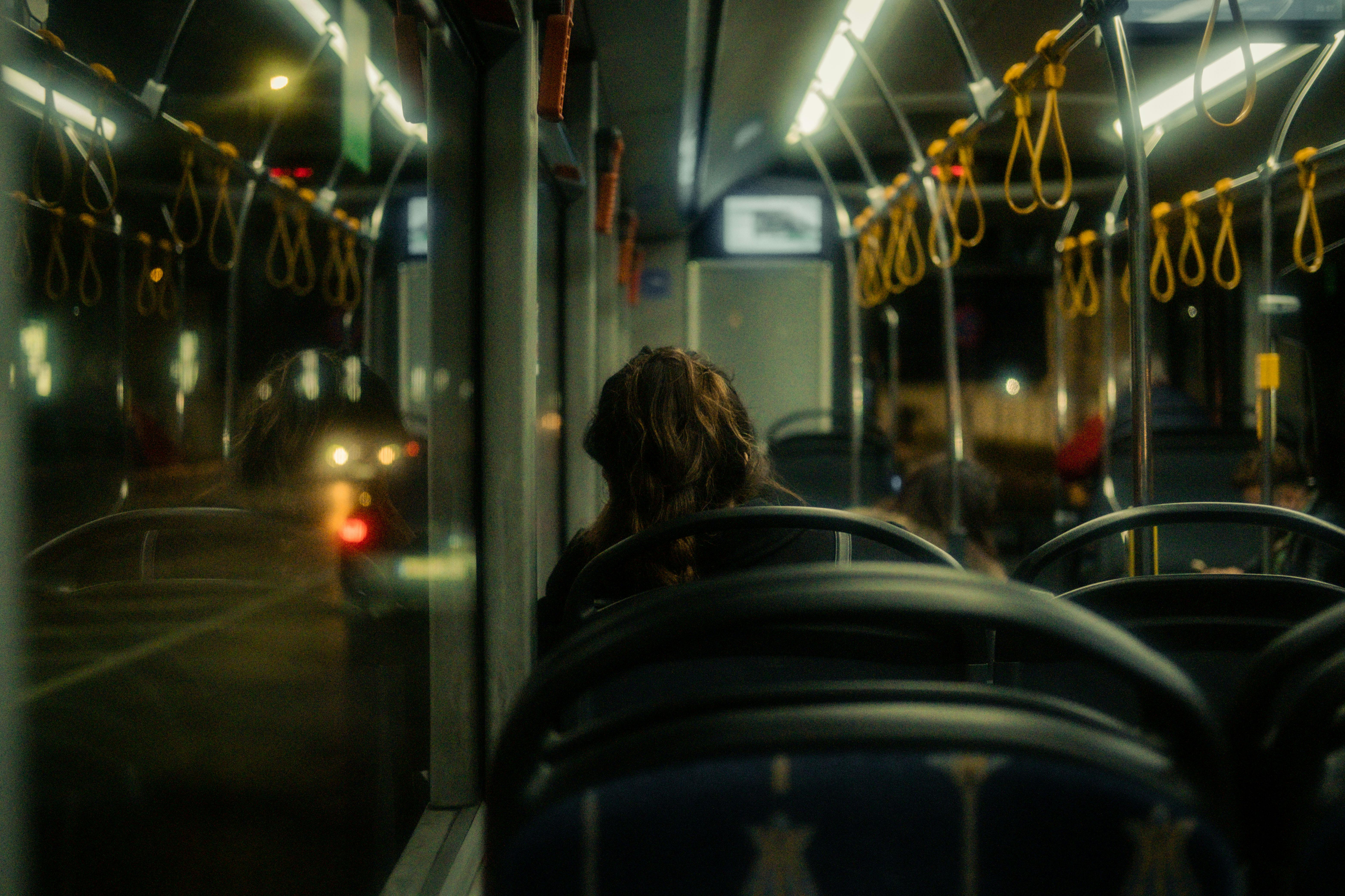 Person Sitting in Empty Night Bus · Free Stock Photo