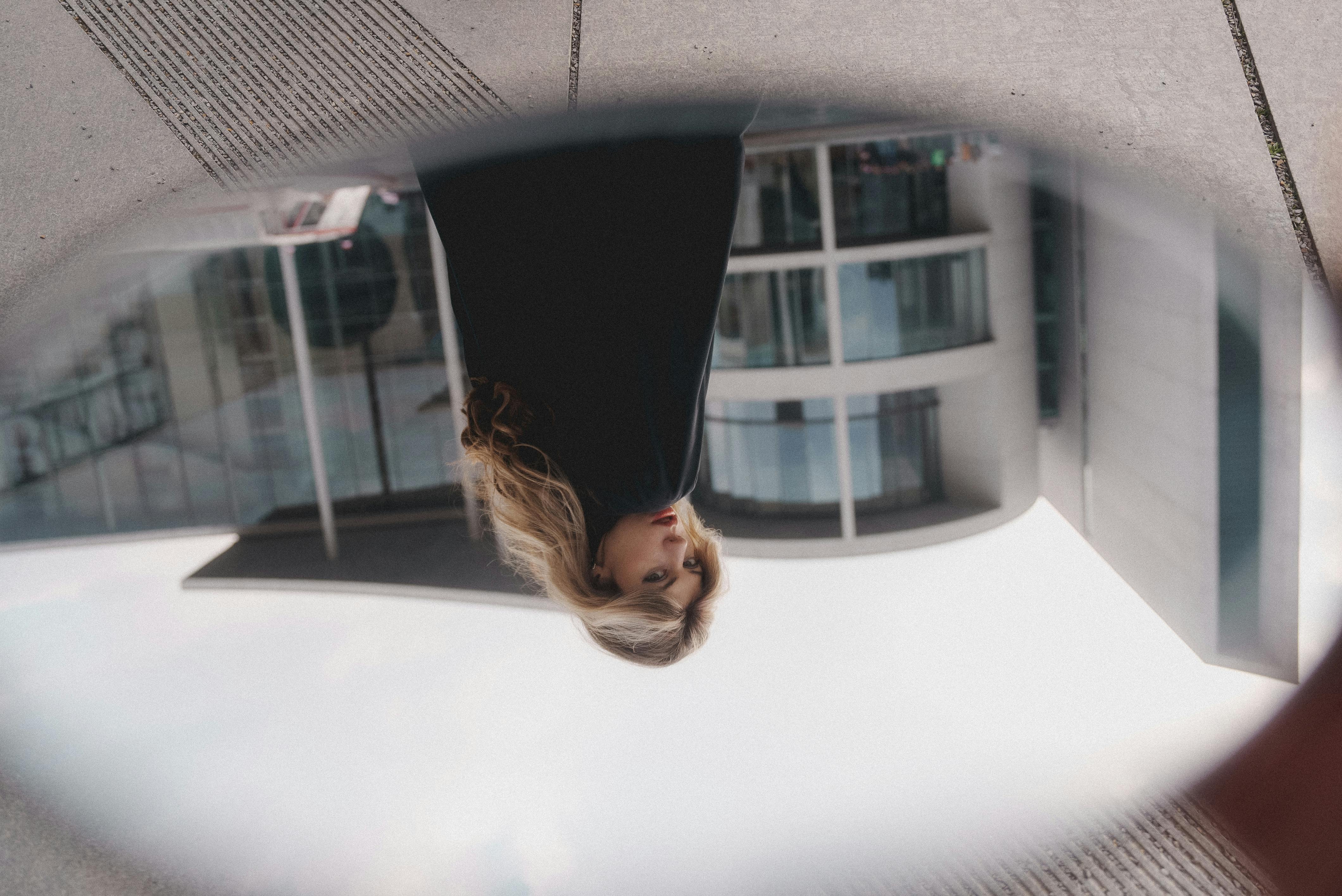Inverted Reflection of a Beautiful Blonde Woman in a Small Mirror · Free Stock Photo