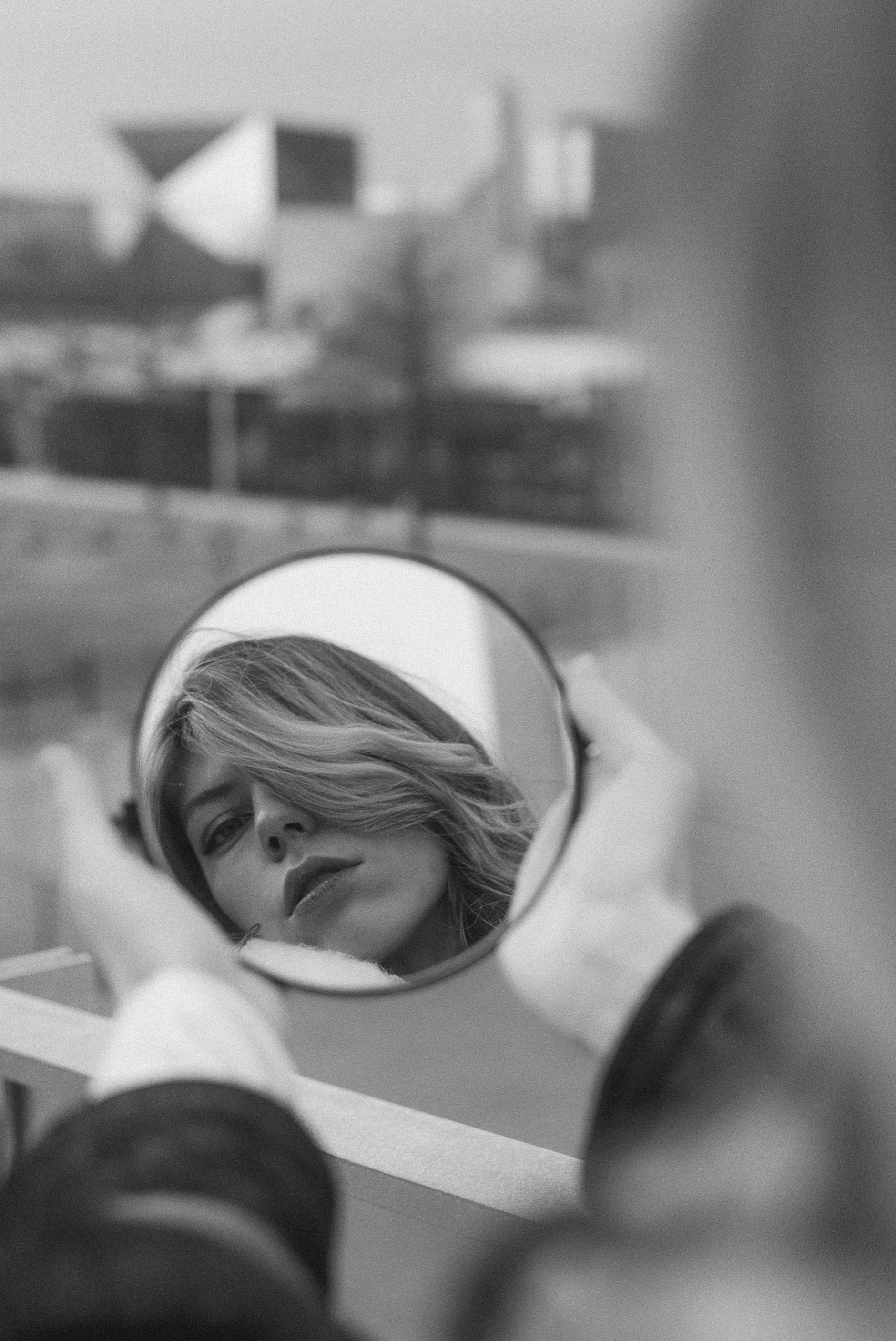Beautiful Model Holding a Small Mirror and Looking at her Reflection in ...
