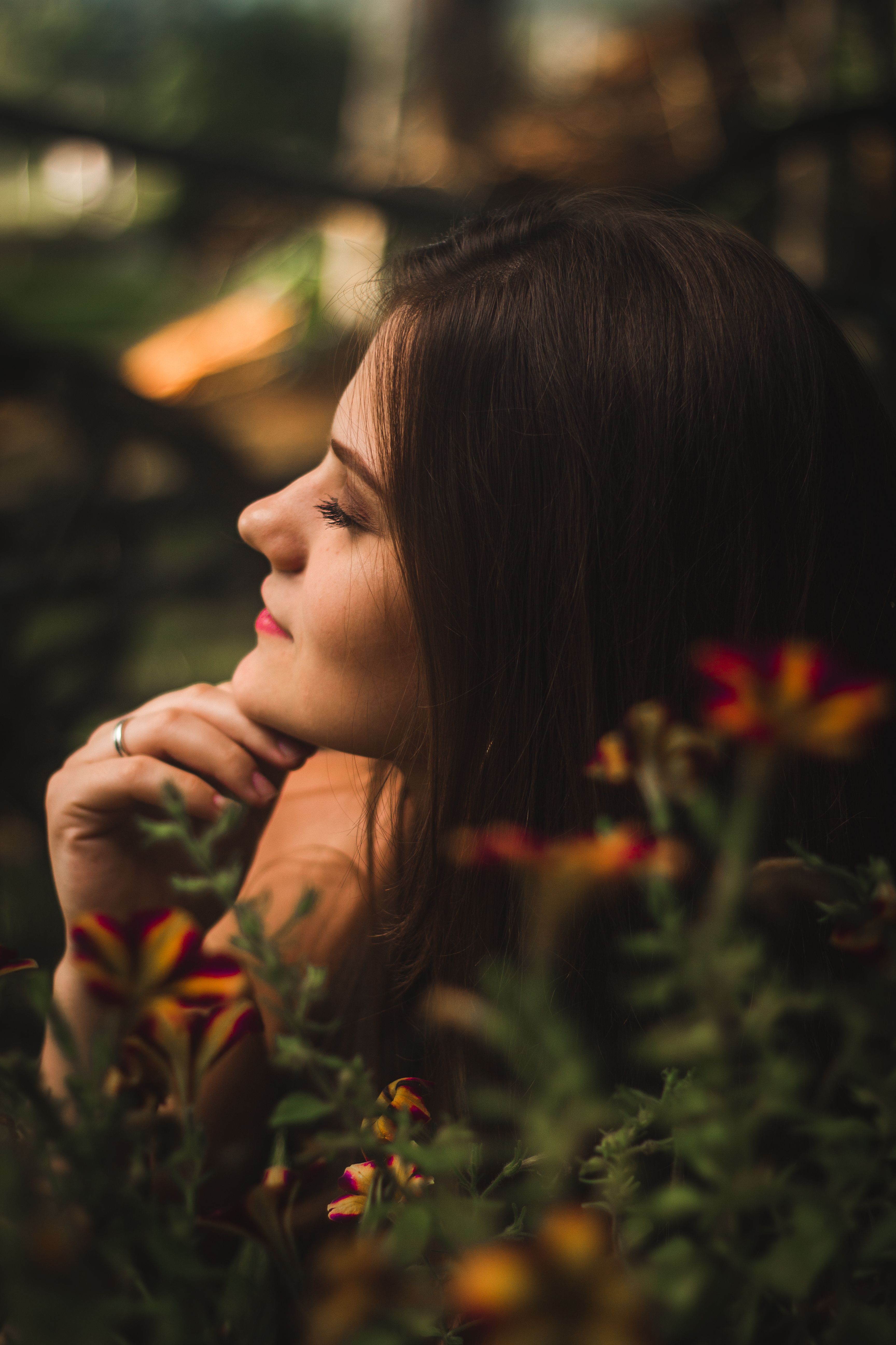 Woman Sitting Behind Flowers · Free Stock Photo