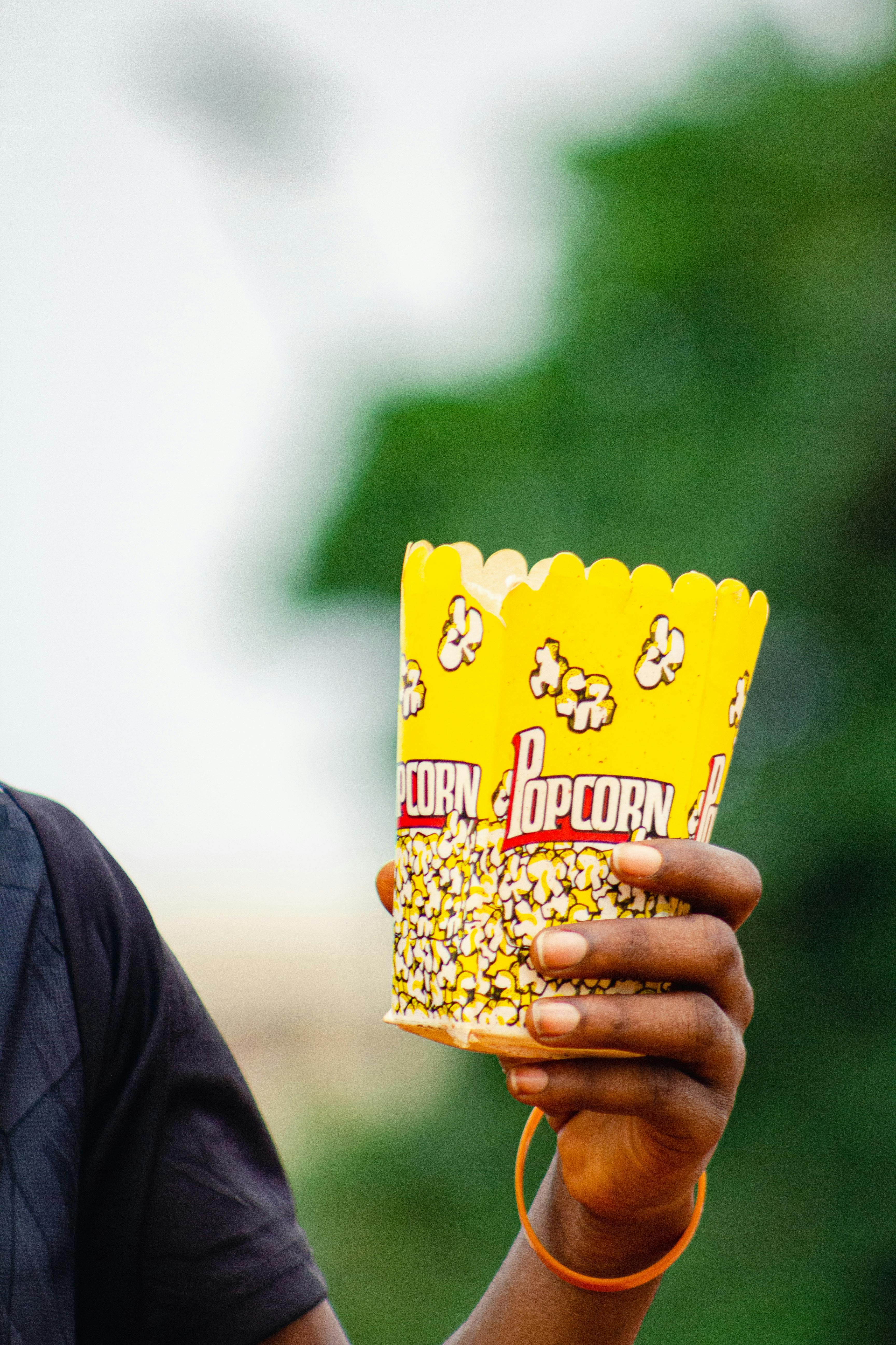 Man Hand Holding Box of Popcorn · Free Stock Photo