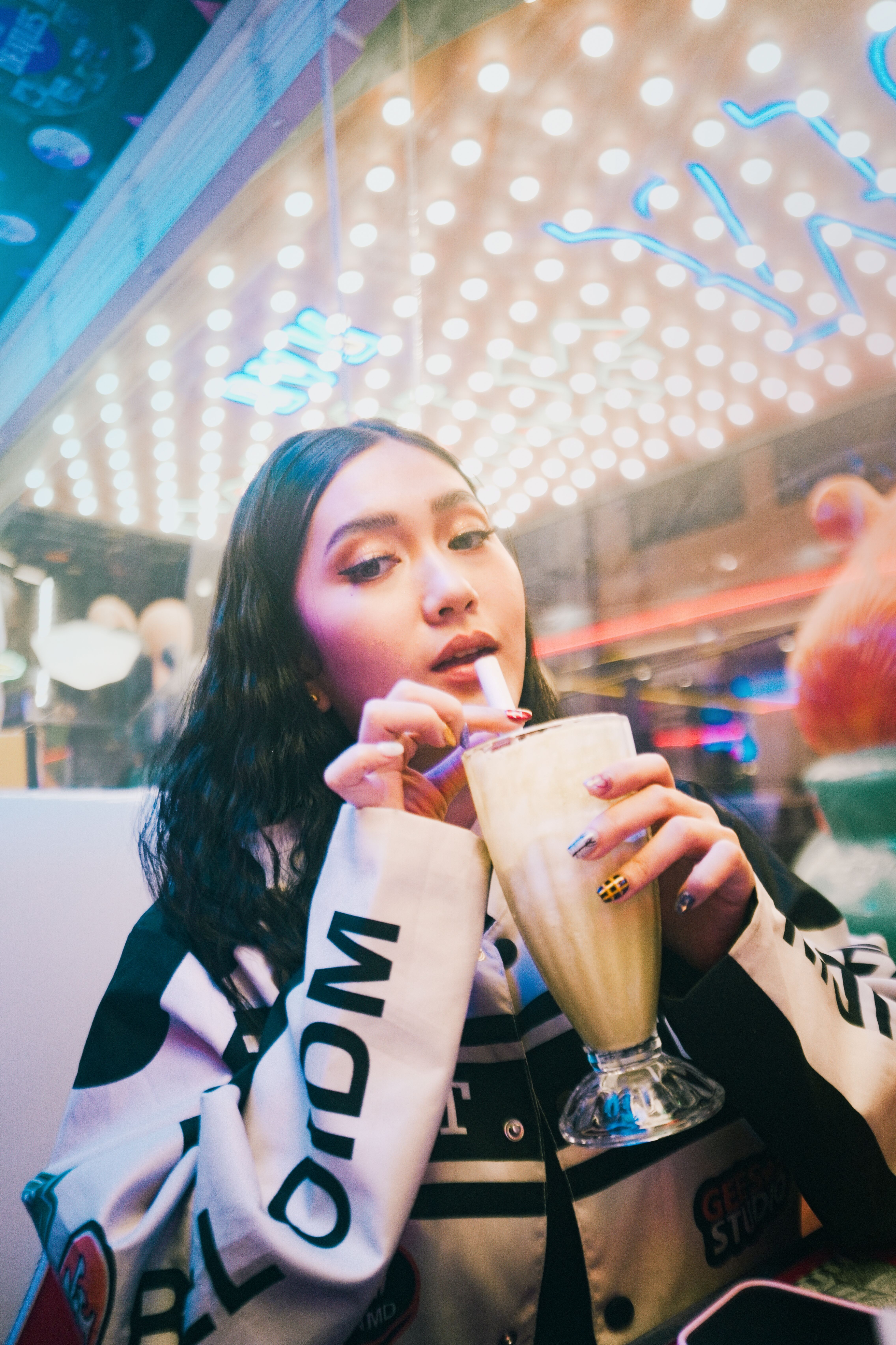 A woman drinking a milkshake in a restaurant · Free Stock Photo
