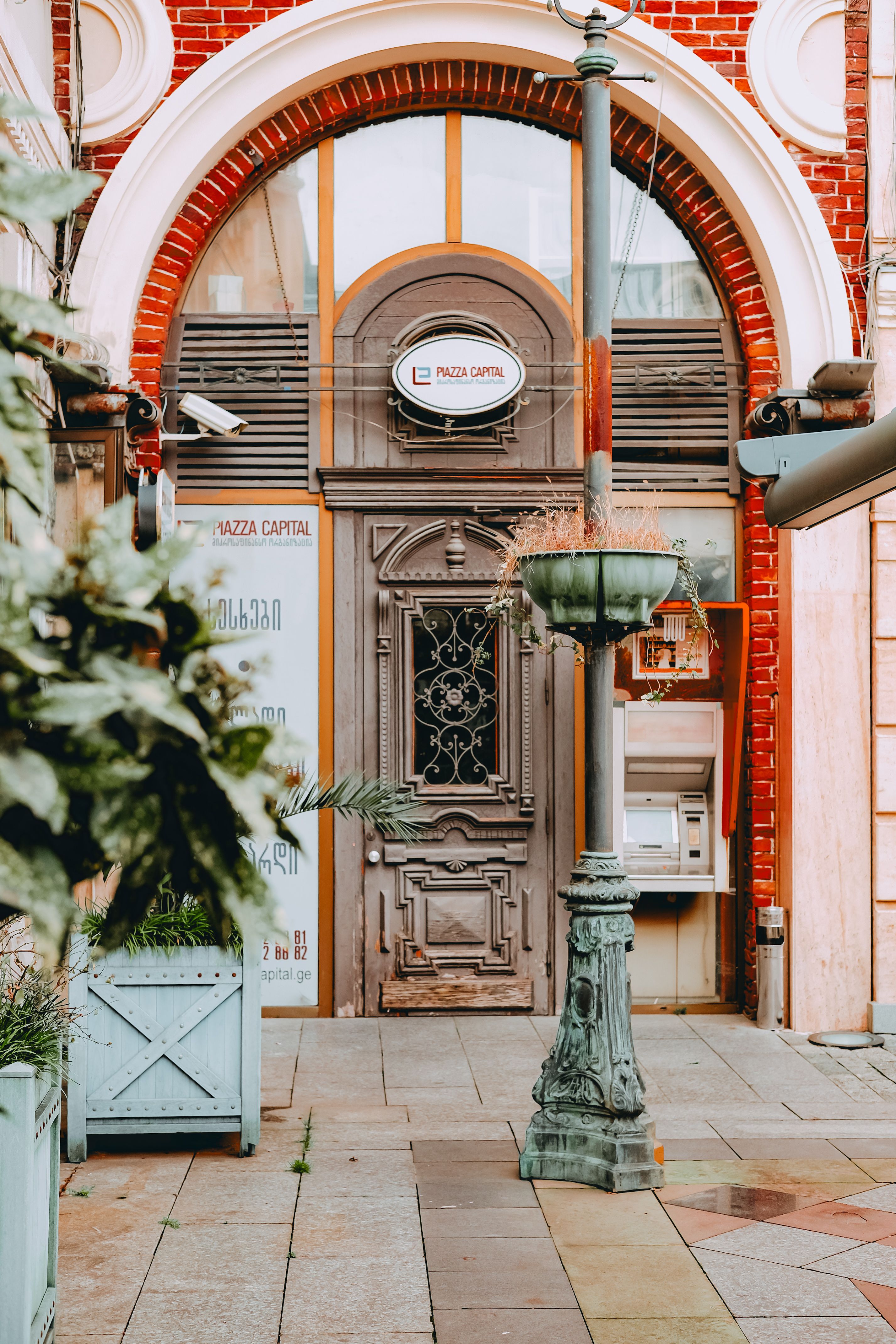 Arched Entrance of the Pizzeria with an Old-Style Door and an ATM ...