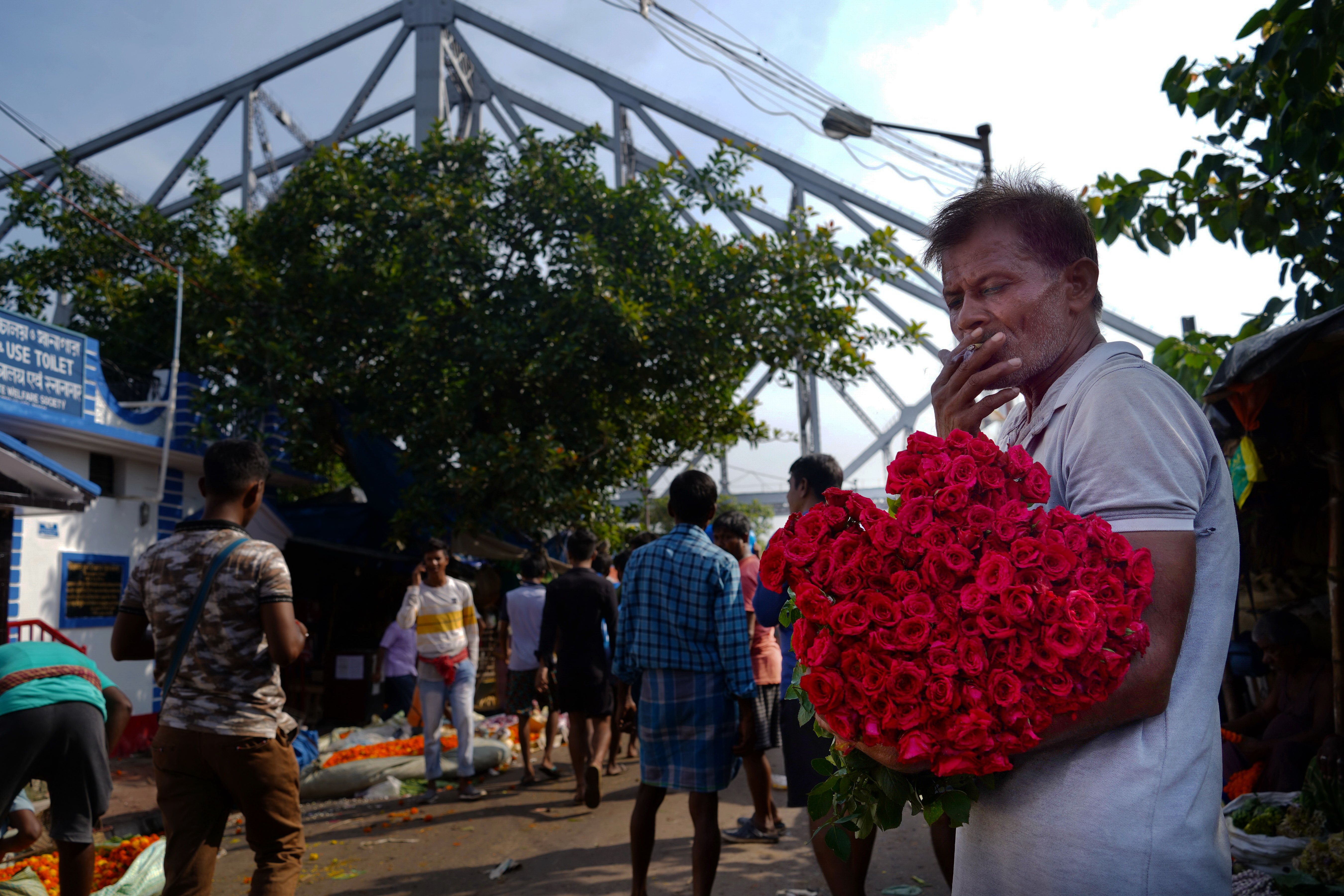 Man Smoking and Standing with Red Roses Bouquet · Free Stock Photo