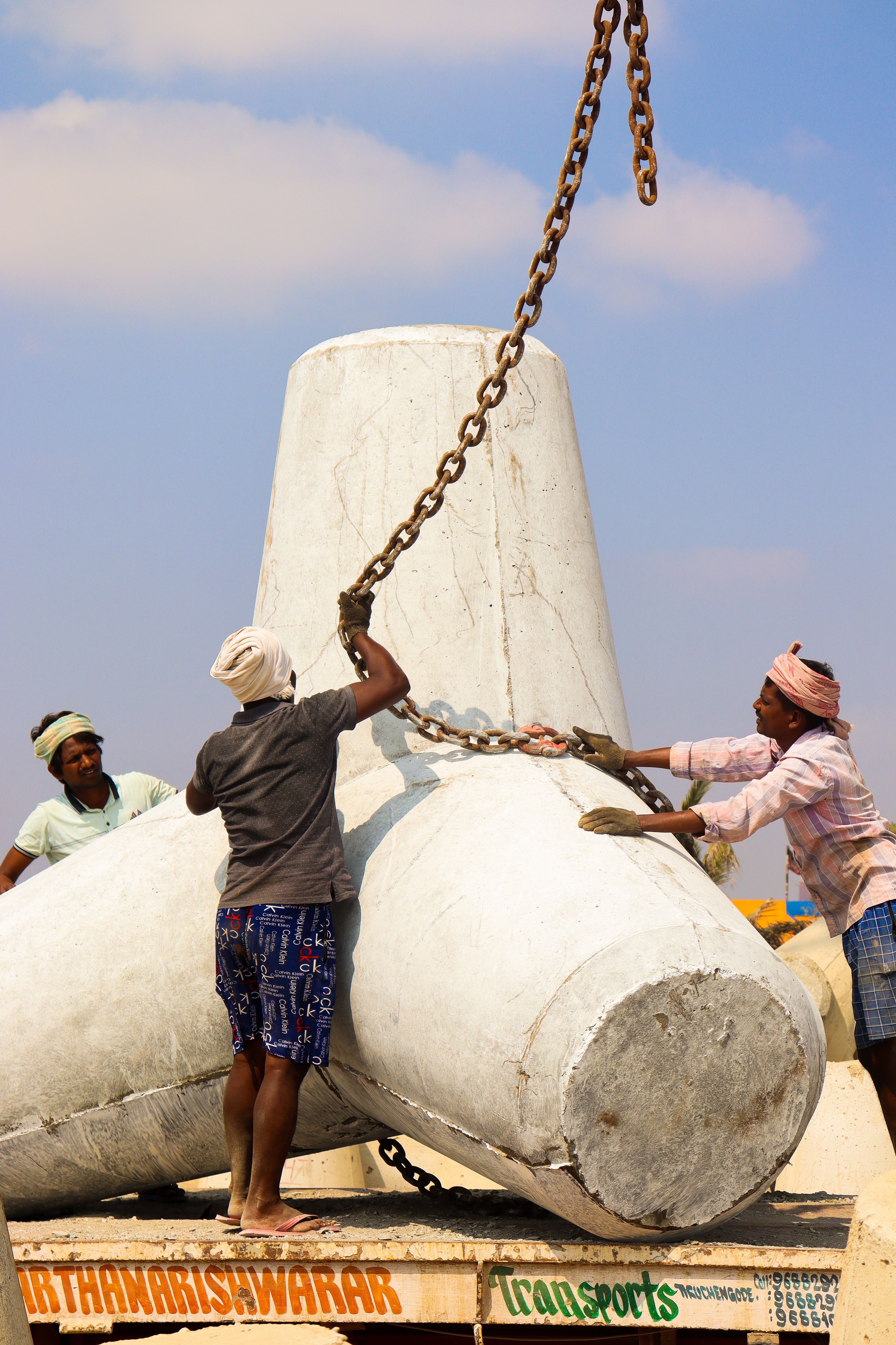 Two men are working on a large concrete structure · Free Stock Photo