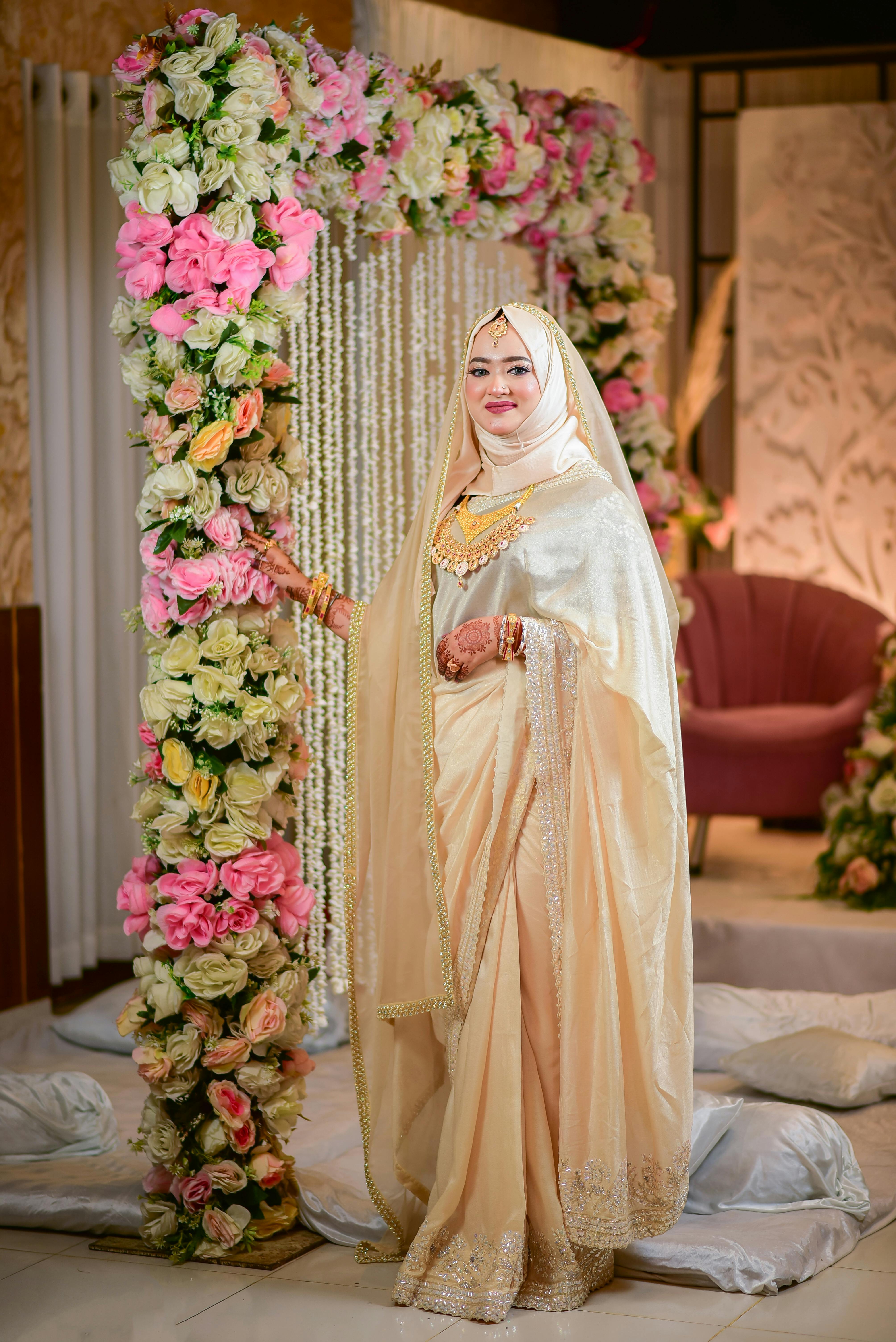 Hijabi Bride Standing in front of Floral Arch · Free Stock Photo