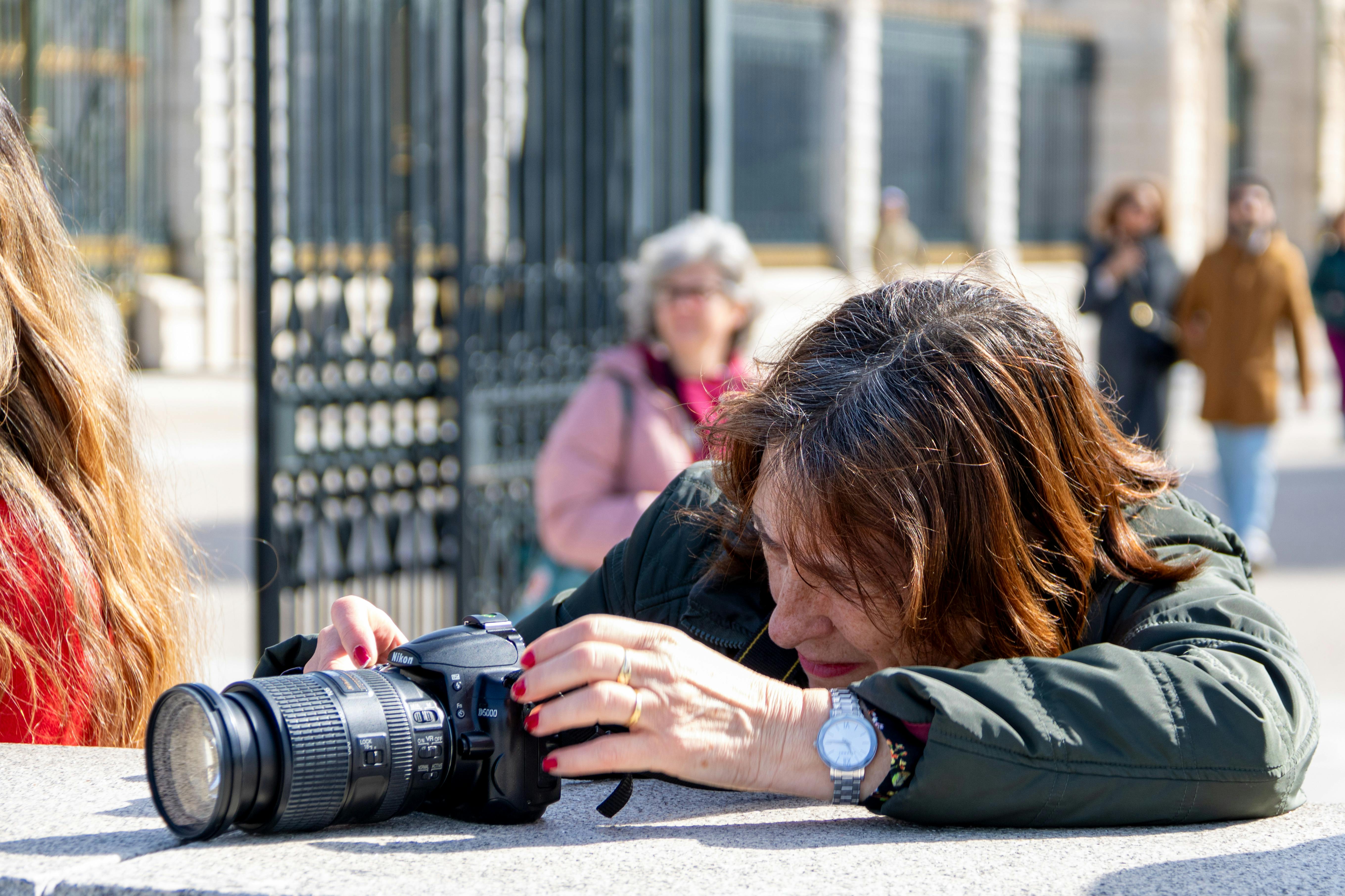 Photographer Leaning Her Camera on a Wall · Free Stock Photo