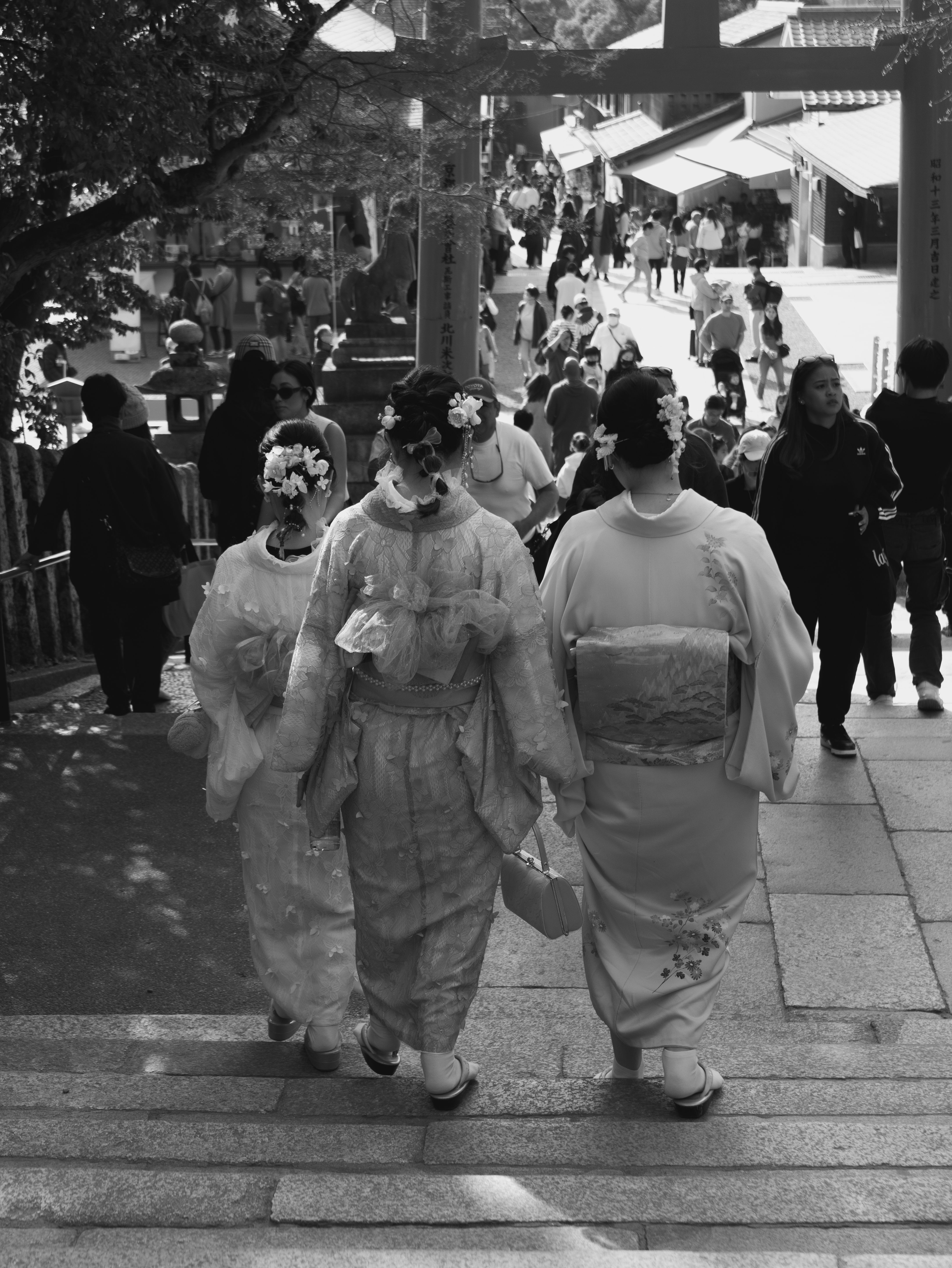 Three women in traditional japanese clothing walking down a street ...