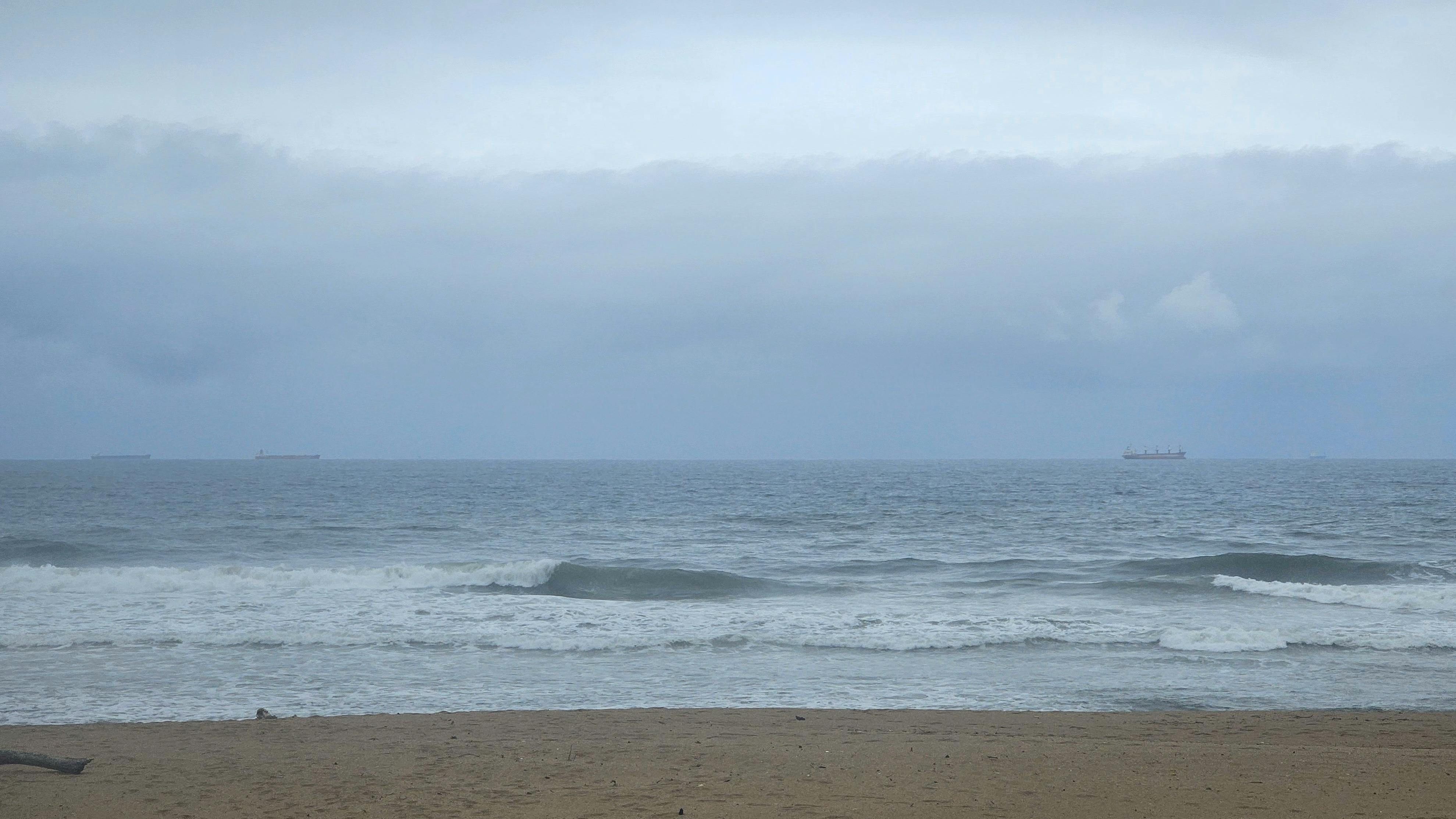 Sandy Beach with Ships Sailing in the Distant Background · Free Stock Photo