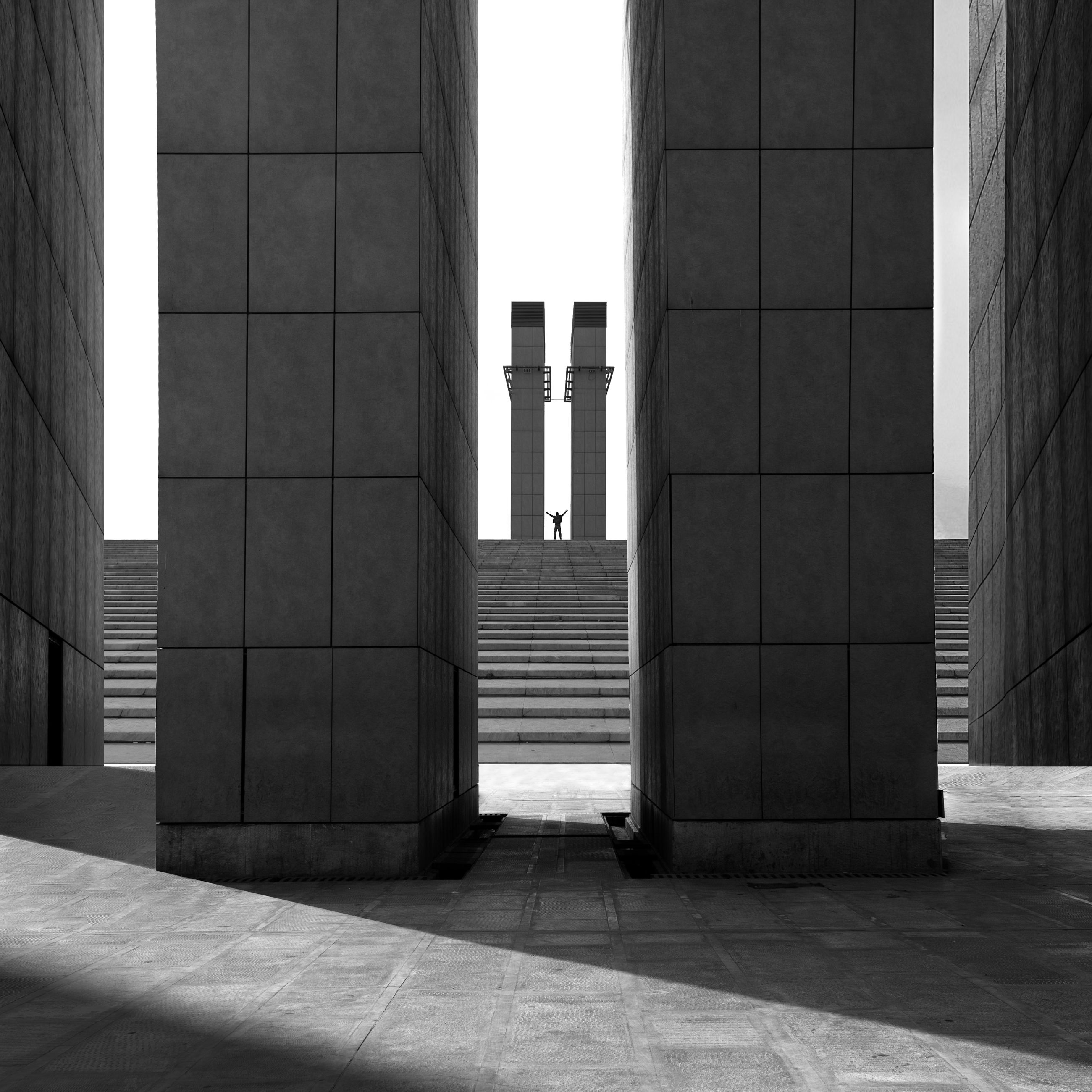 Person Standing behind Stairs and Pillars of Building · Free Stock Photo