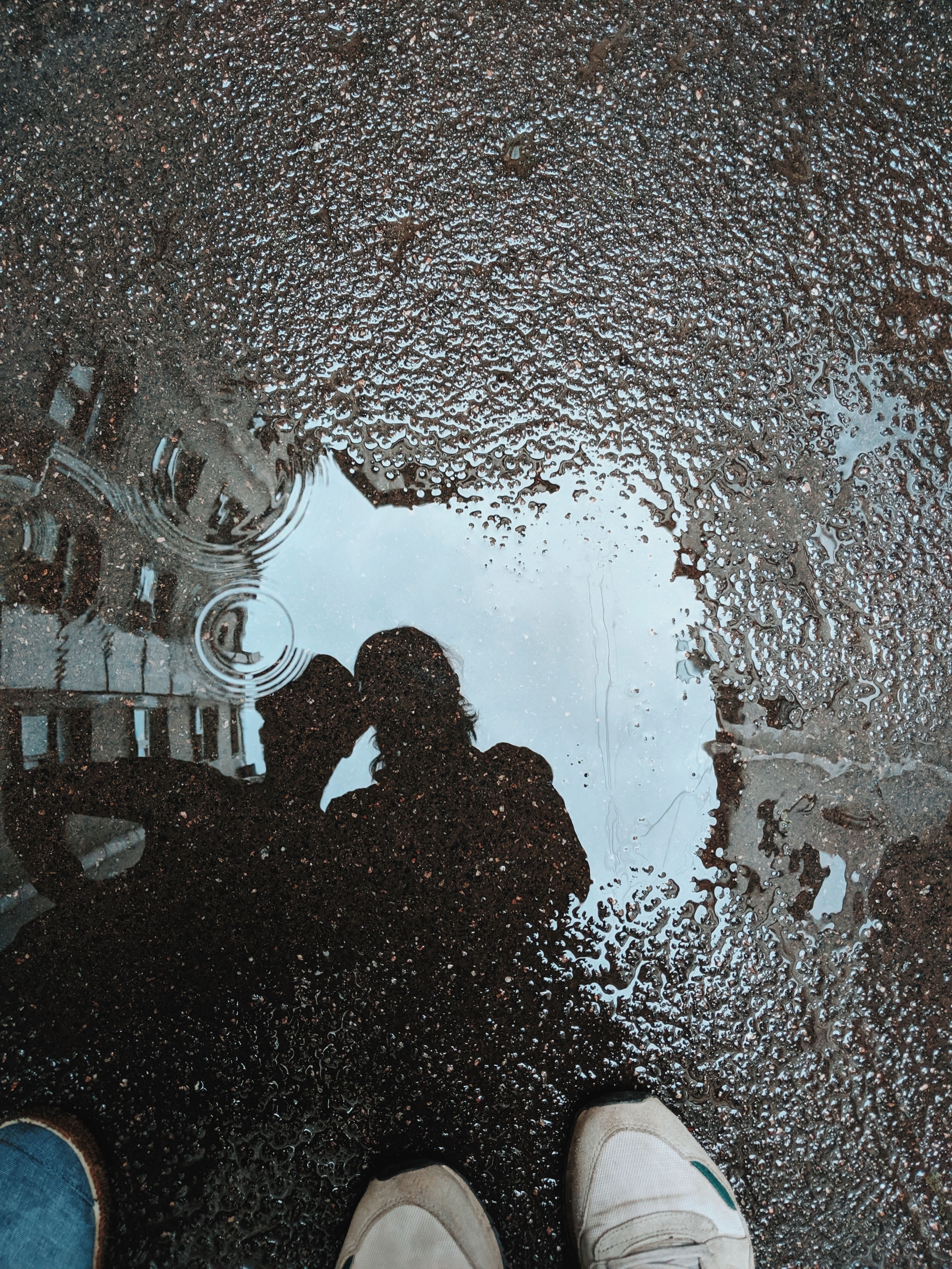 A person standing in the middle of a puddle with their shadow · Free ...
