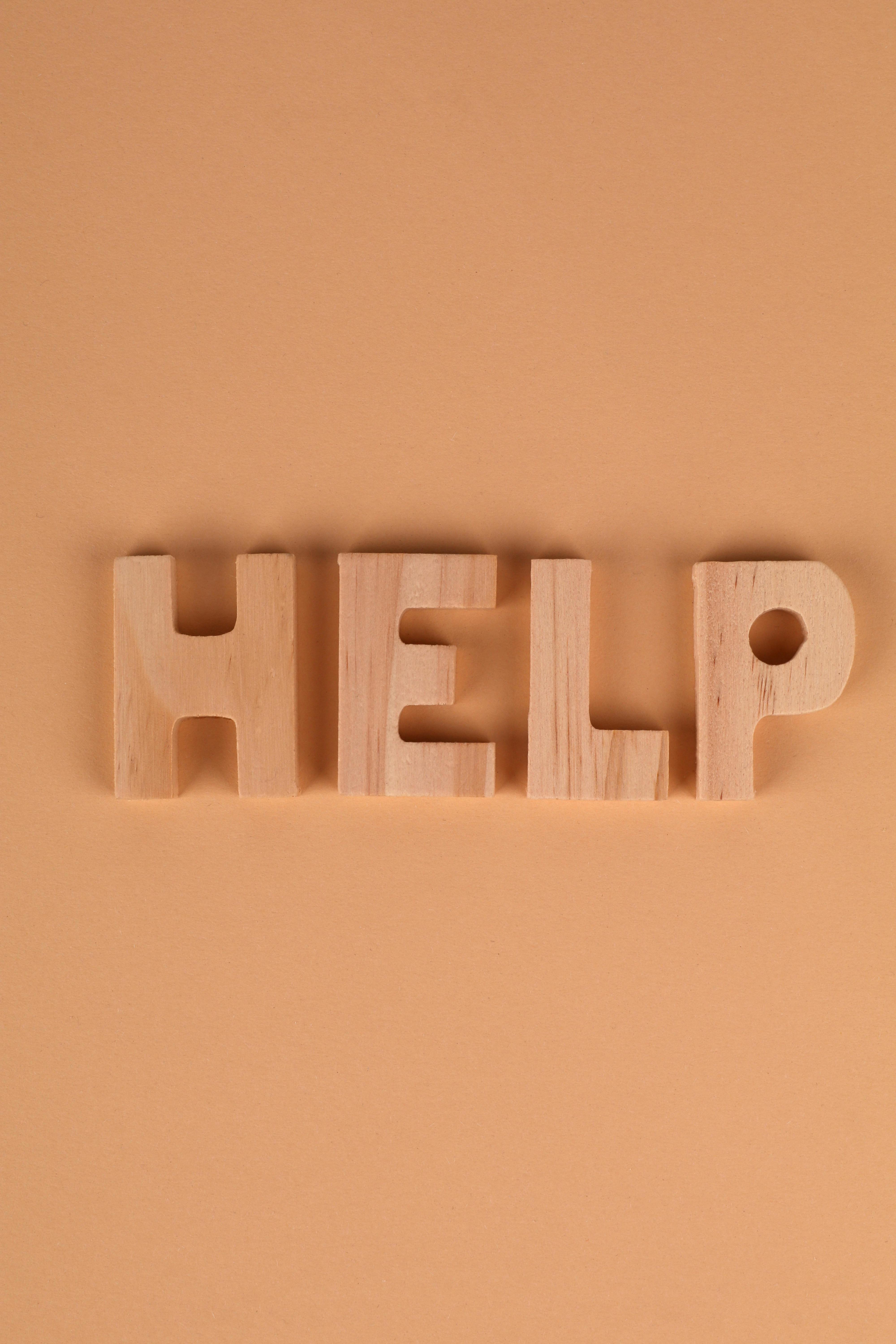 Free Wooden letters spelling 'HELP' on a simple brown background ...