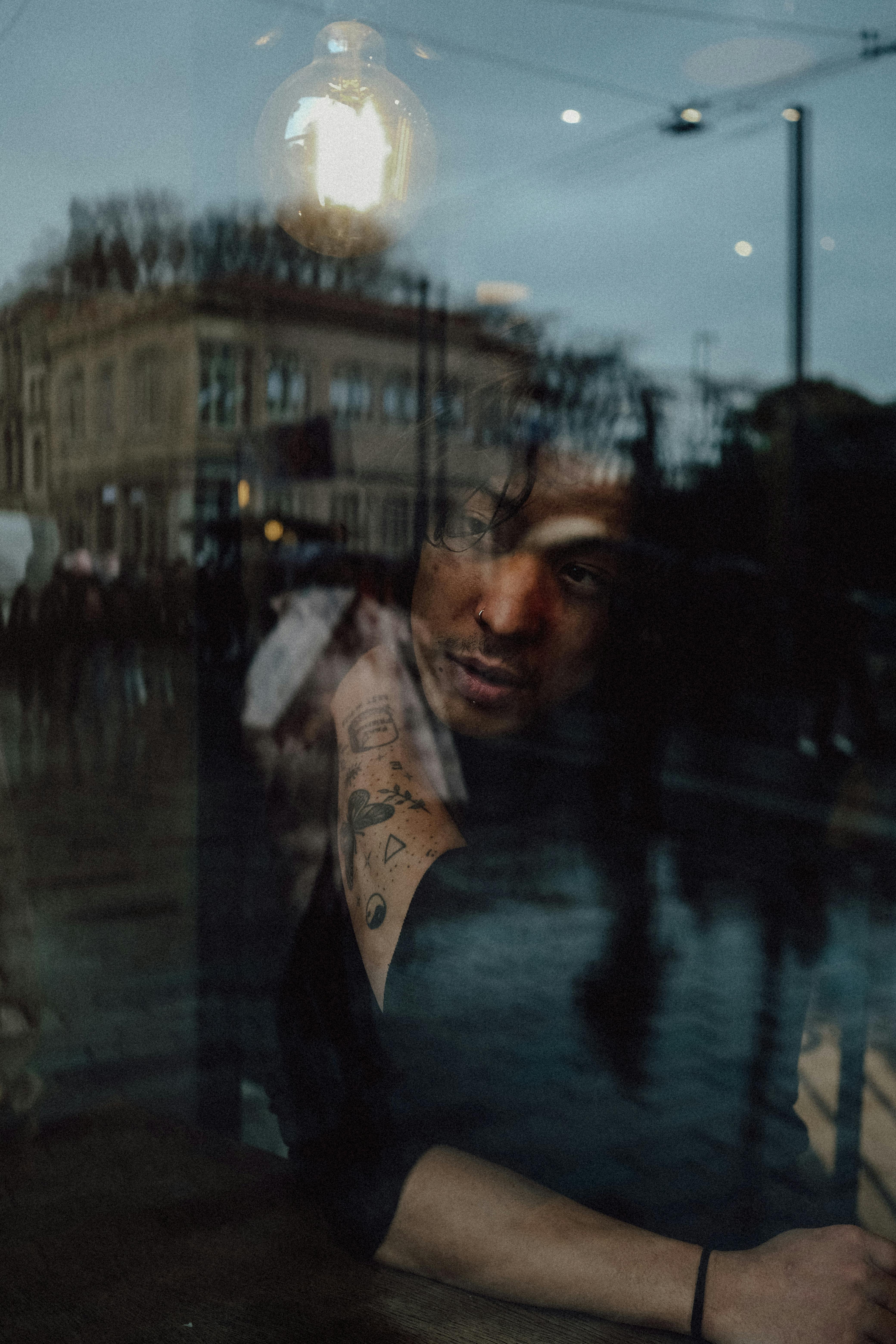 Man Sitting behind Glass Window · Free Stock Photo