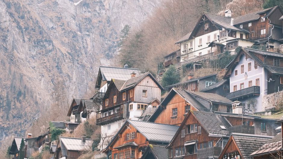 Charming wooden houses in the alpine village of Hallstatt, Austria, nestled against majestic mountains.