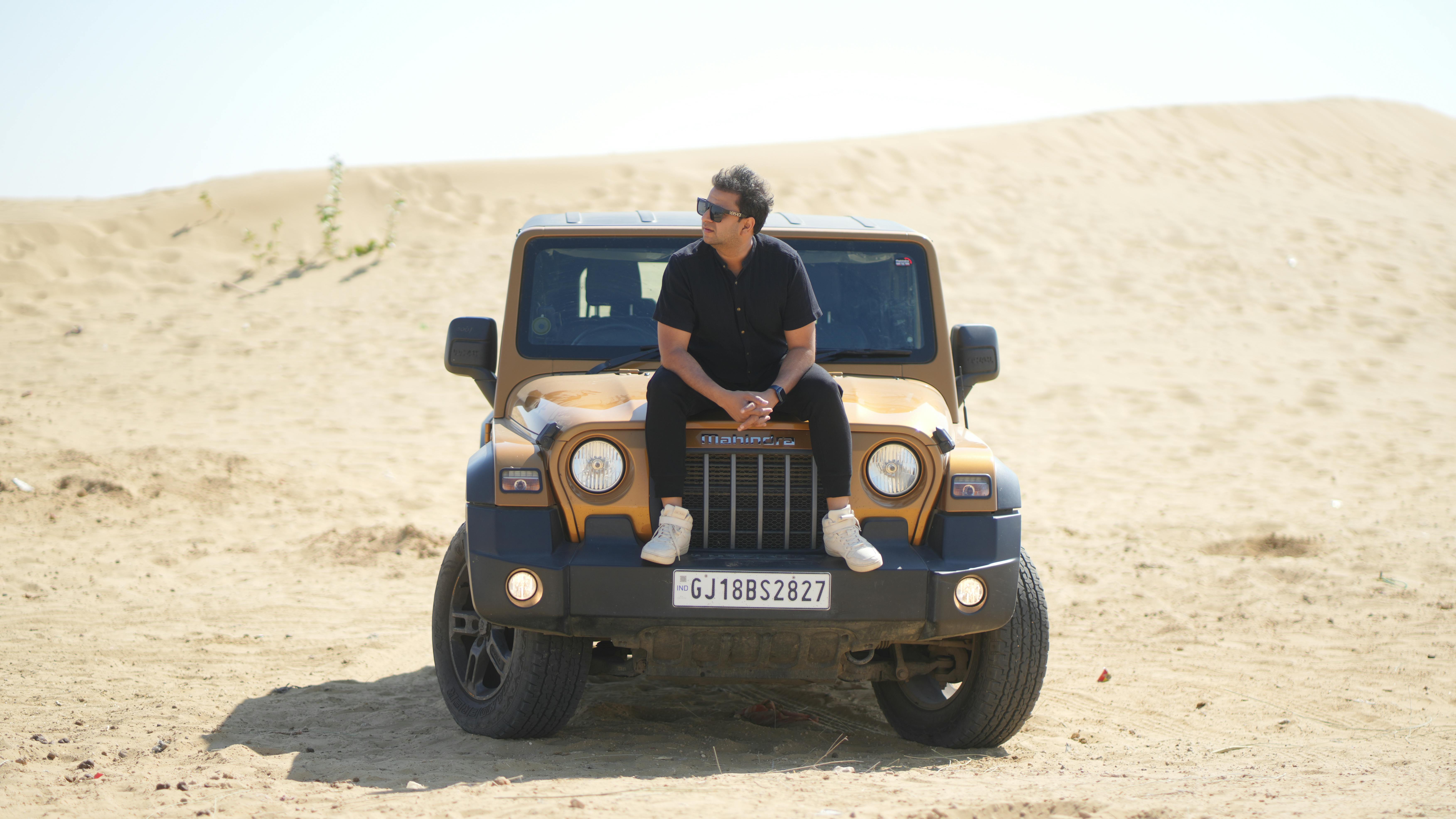 Man with Sunglasses Sitting on Mahindra Thar · Free Stock Photo