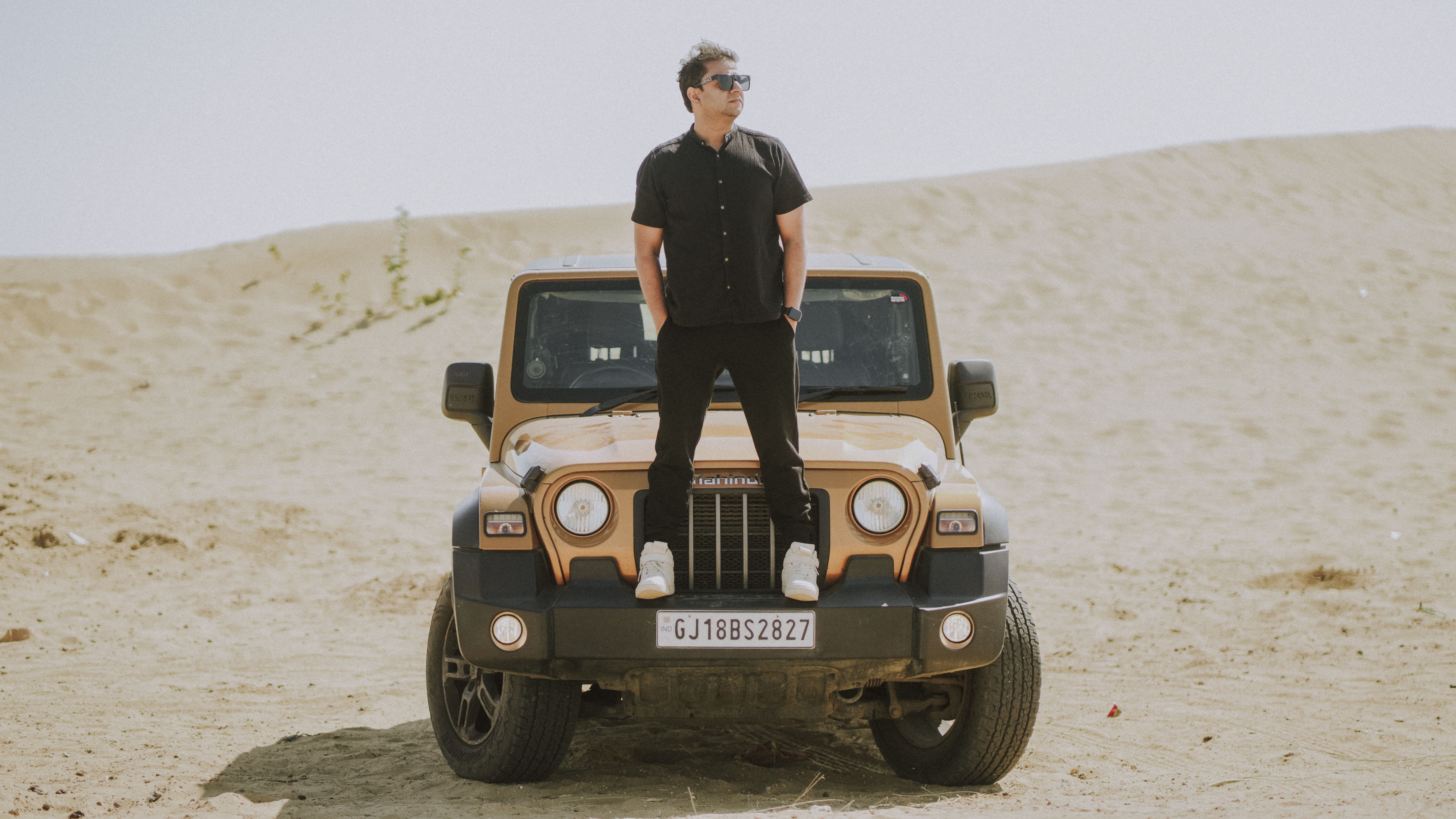 Driver Standing on the Bumper of an Off-road Vehicle in the Desert ...