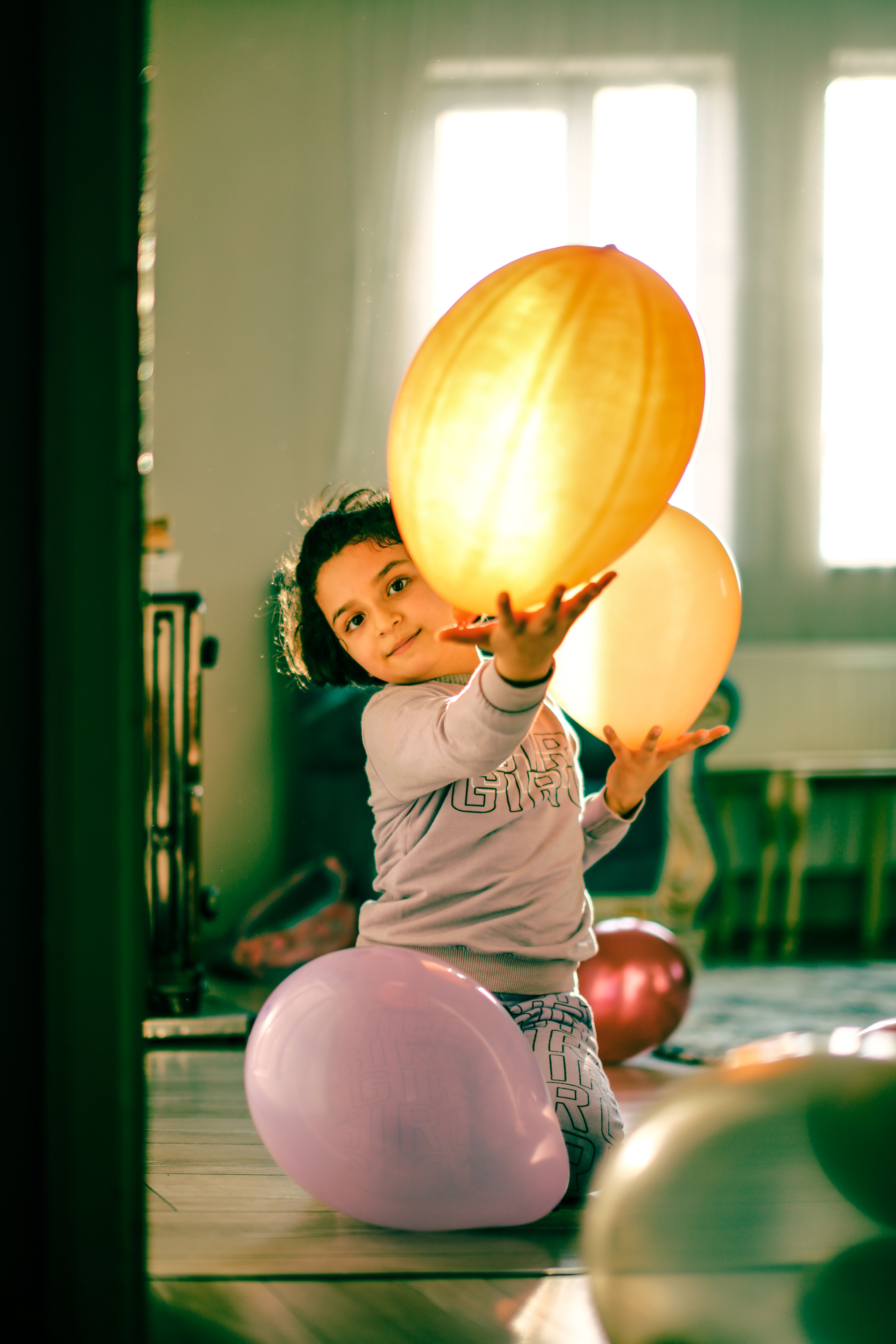 Girl Sitting and Playing with Balloons · Free Stock Photo