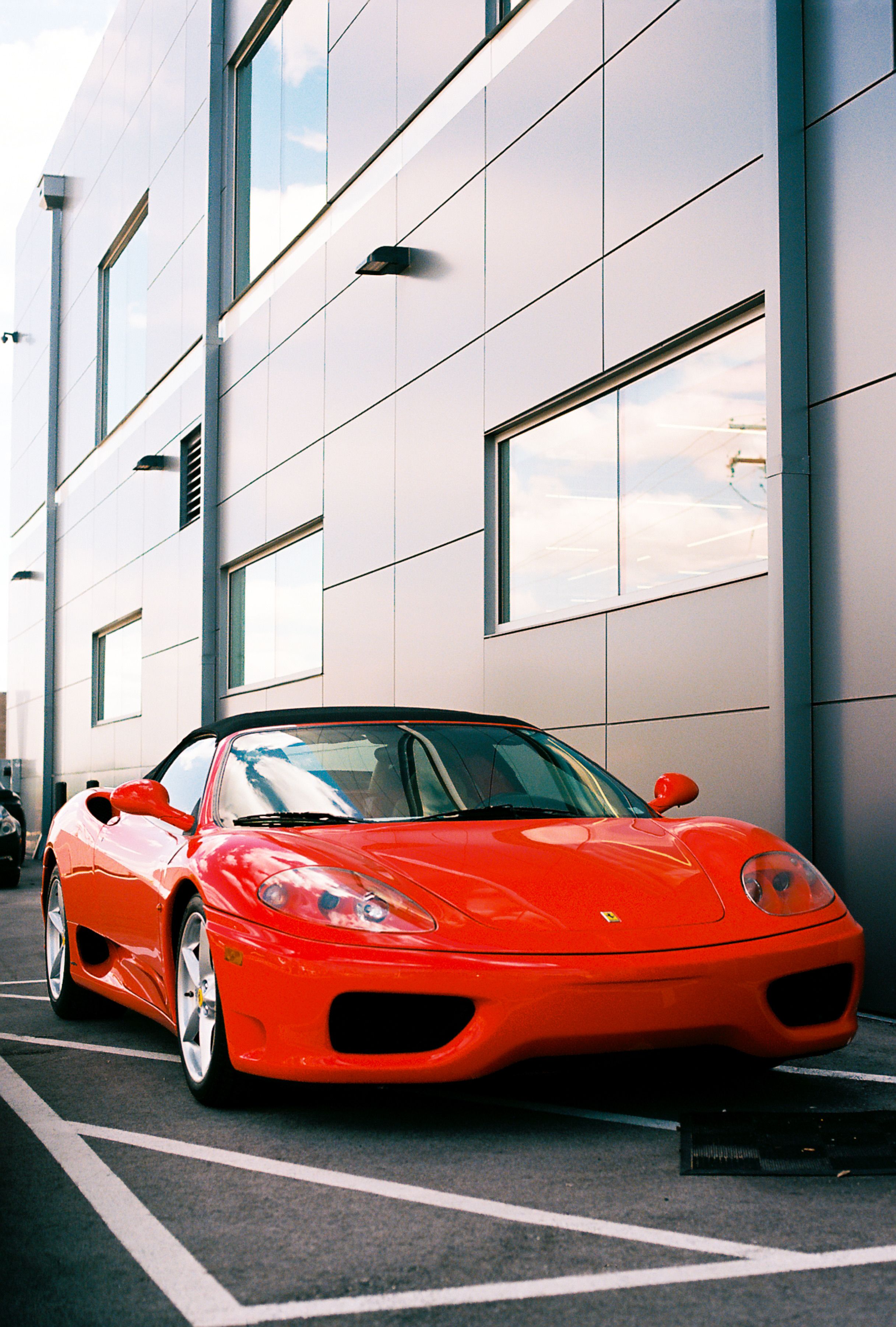 A red ferrari parked in front of a building · Free Stock Photo