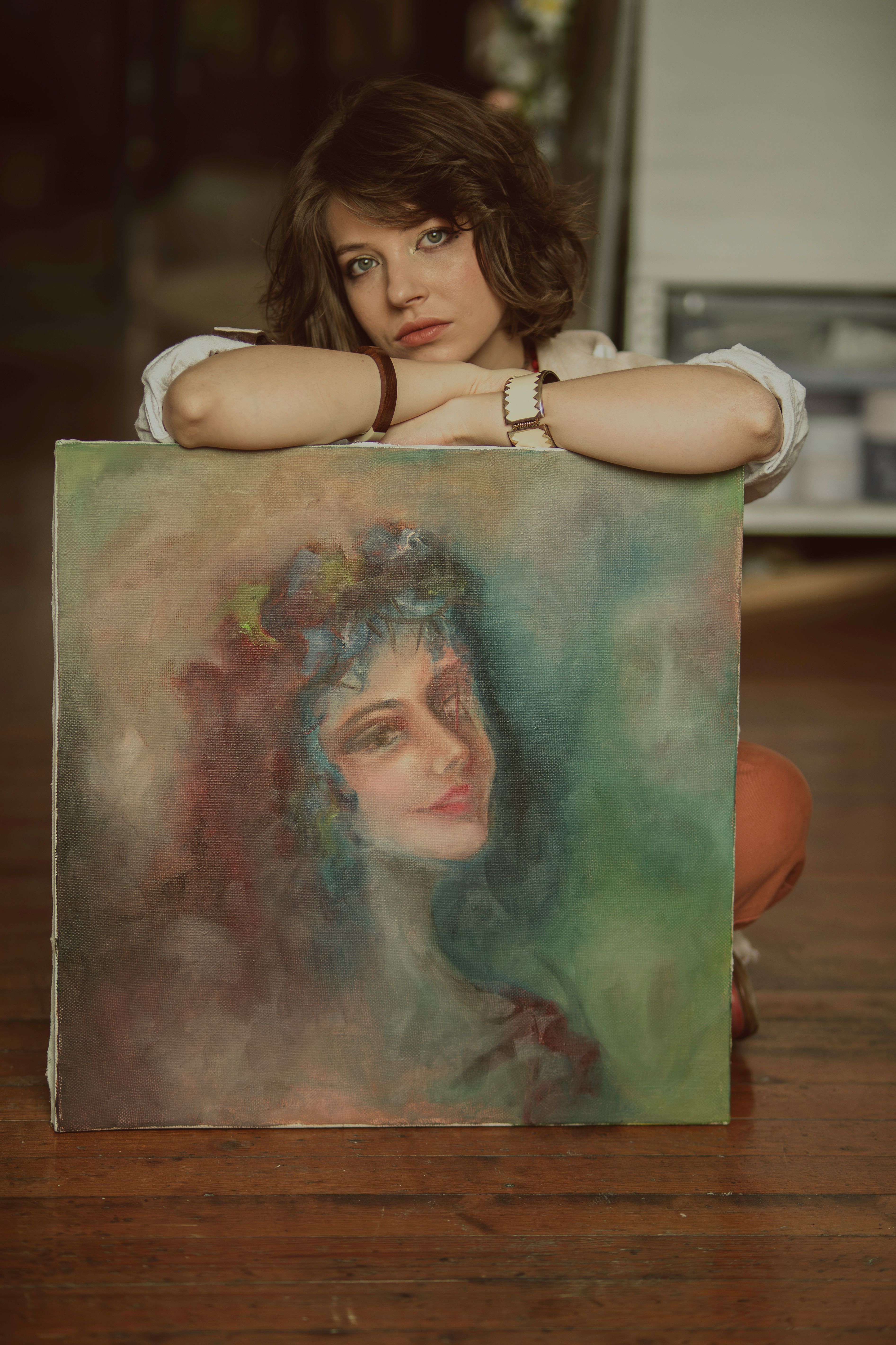 Pretty Woman Crouching with Painting on Canvas · Free Stock Photo
