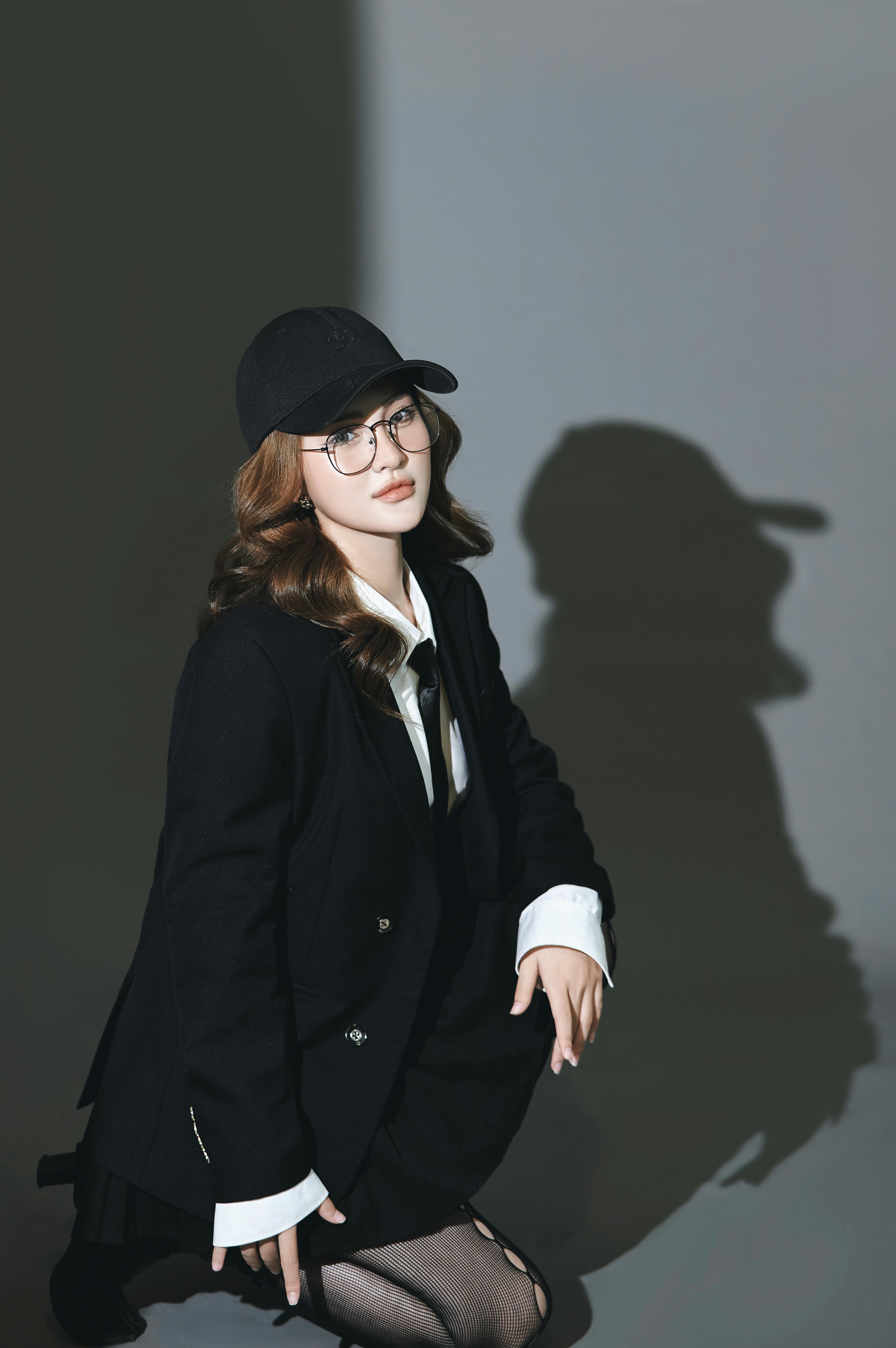 Woman Kneeling in Cap and Black Suit · Free Stock Photo
